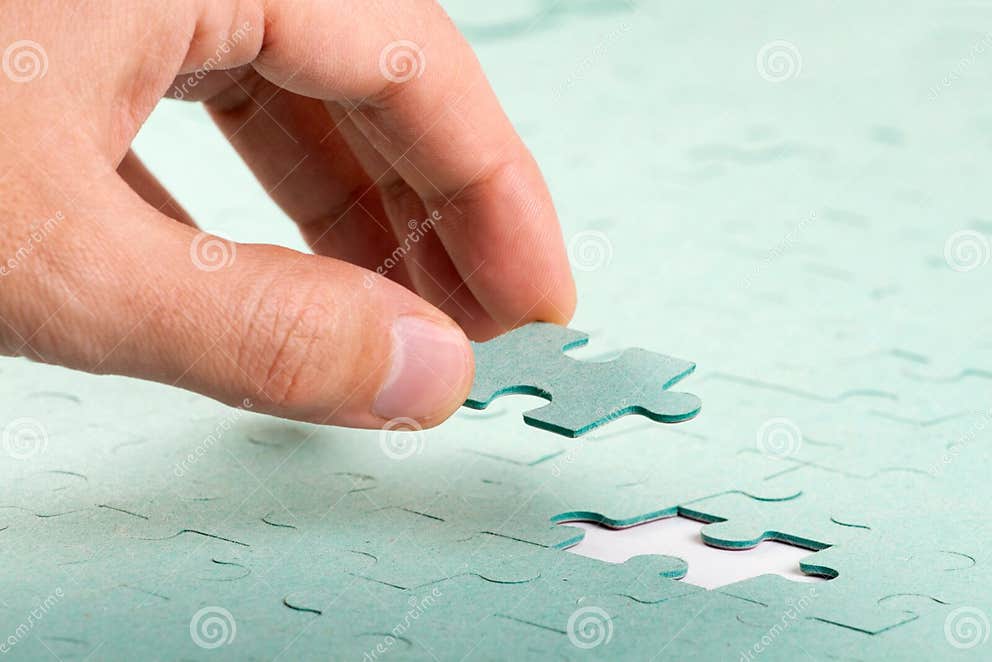 Hand Inserting Missing Piece of Jigsaw Puzzle Stock Photo - Image of ...
