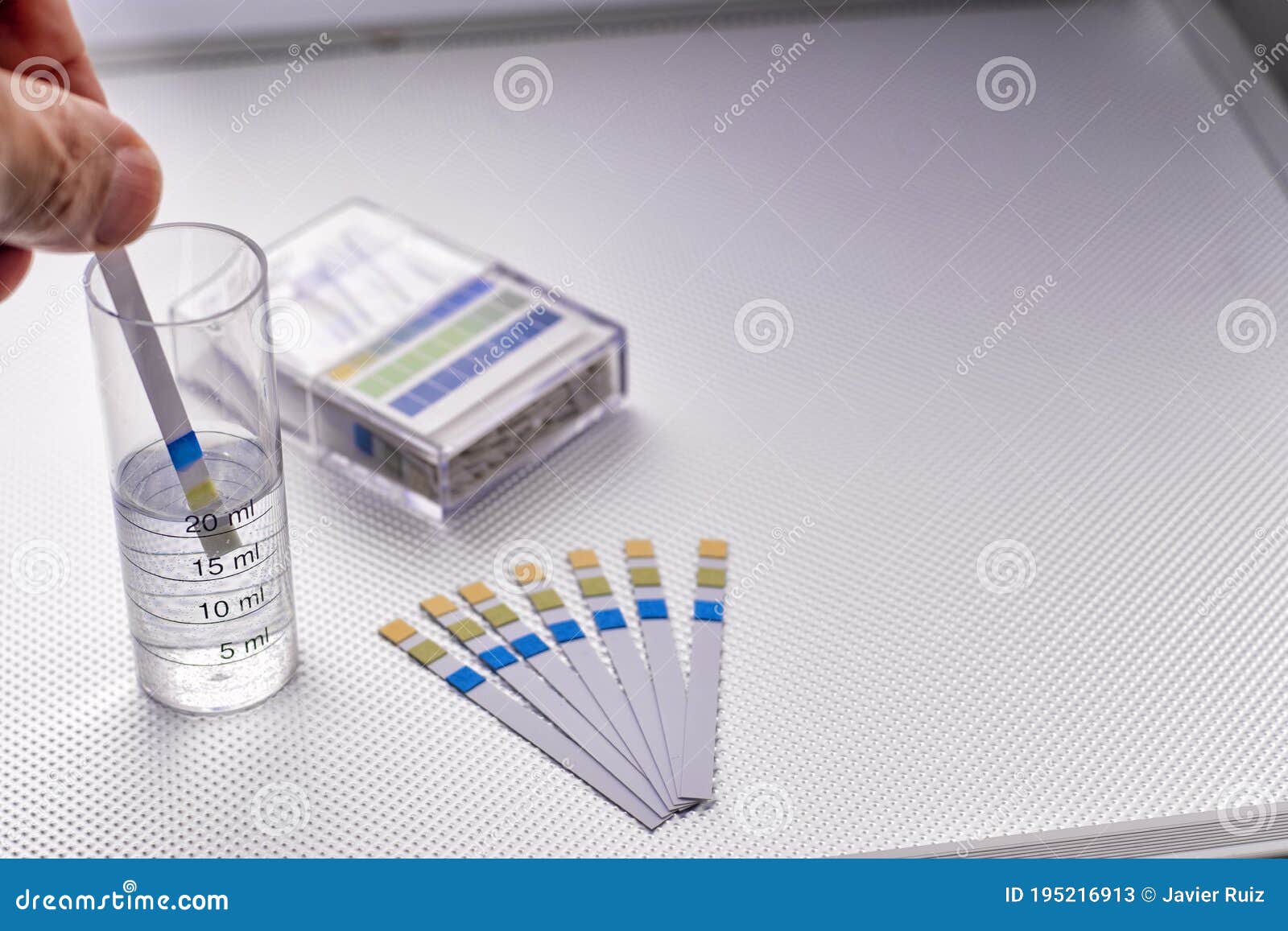 Hand Inserting a Ph Control Strip into a Graduated Cylinder with Water ...
