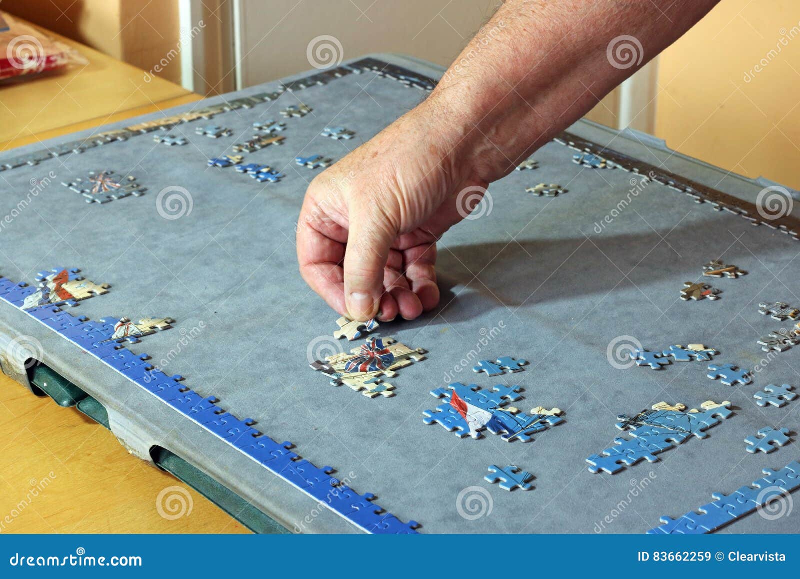 Hand Inserting a Piece of Jigsaw Puzzle. Stock Image - Image of board ...