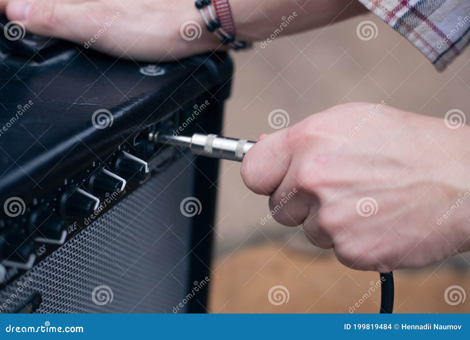 Hand Inserts a Cord Jack into a Combo Amplifier for Electric Guitar ...
