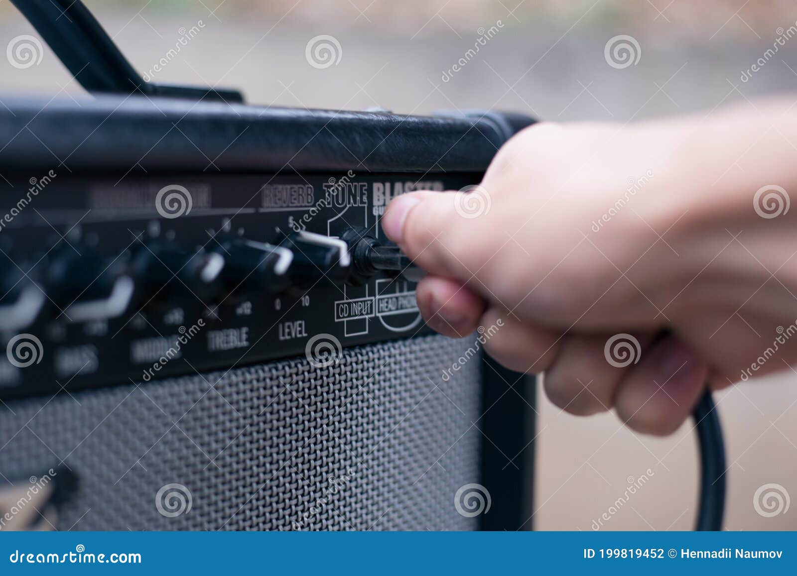 Hand Inserts a Cord Jack into a Combo Amplifier for Electric Guitar ...