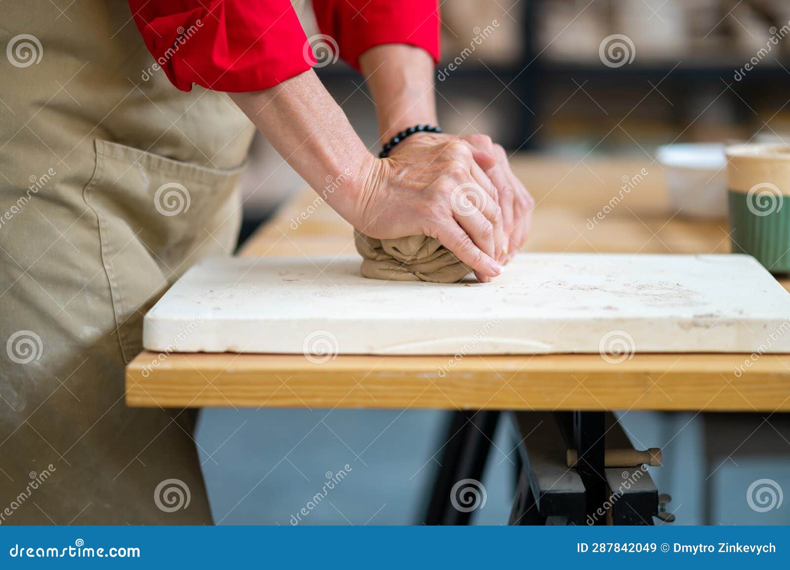 Unrecognizable Woman Wedging Clay with Hands Standing Behind Table in ...