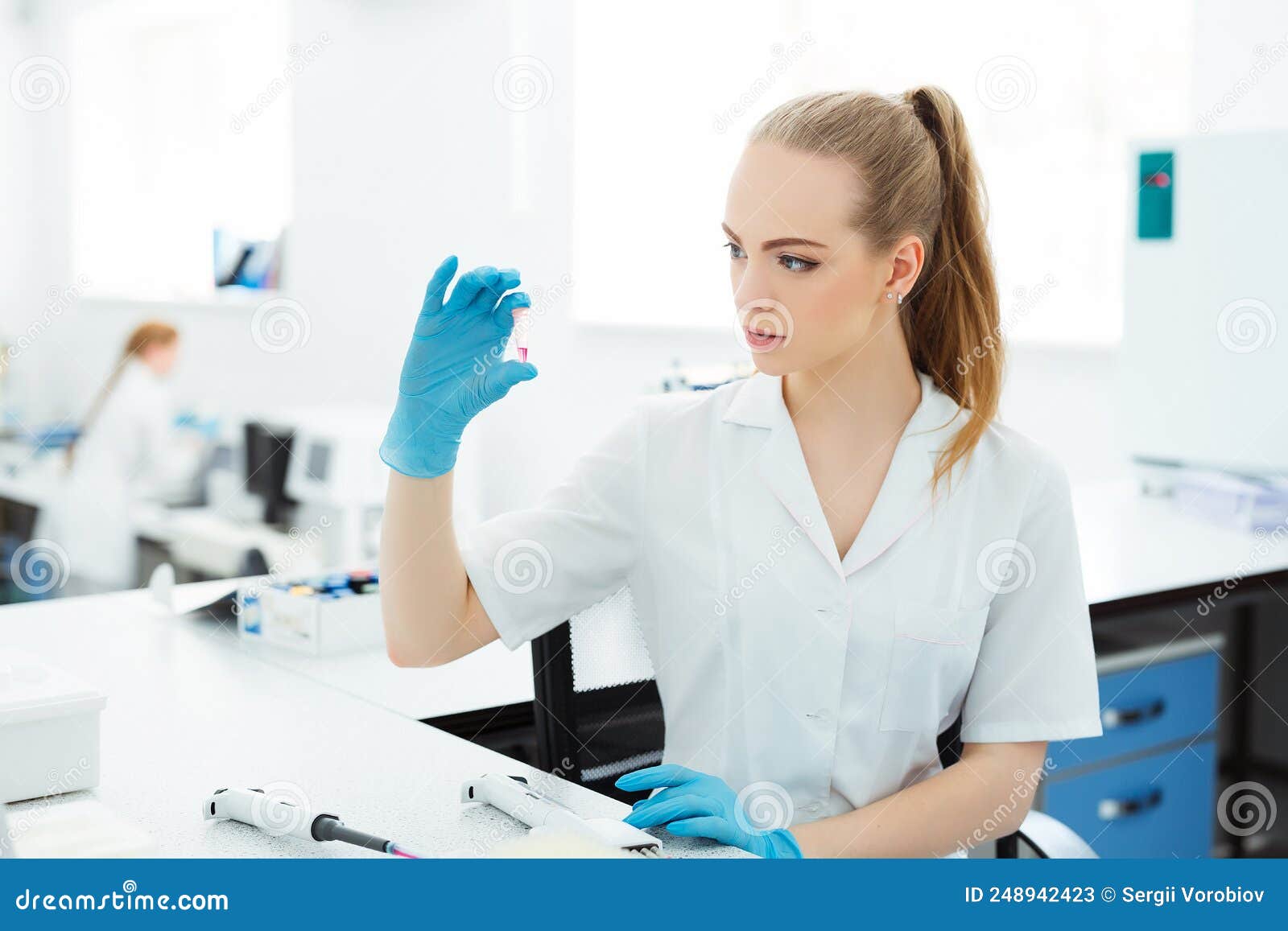 Hand of a Lab Technician Holding a Mini Test Tube with Blood Sample for ...