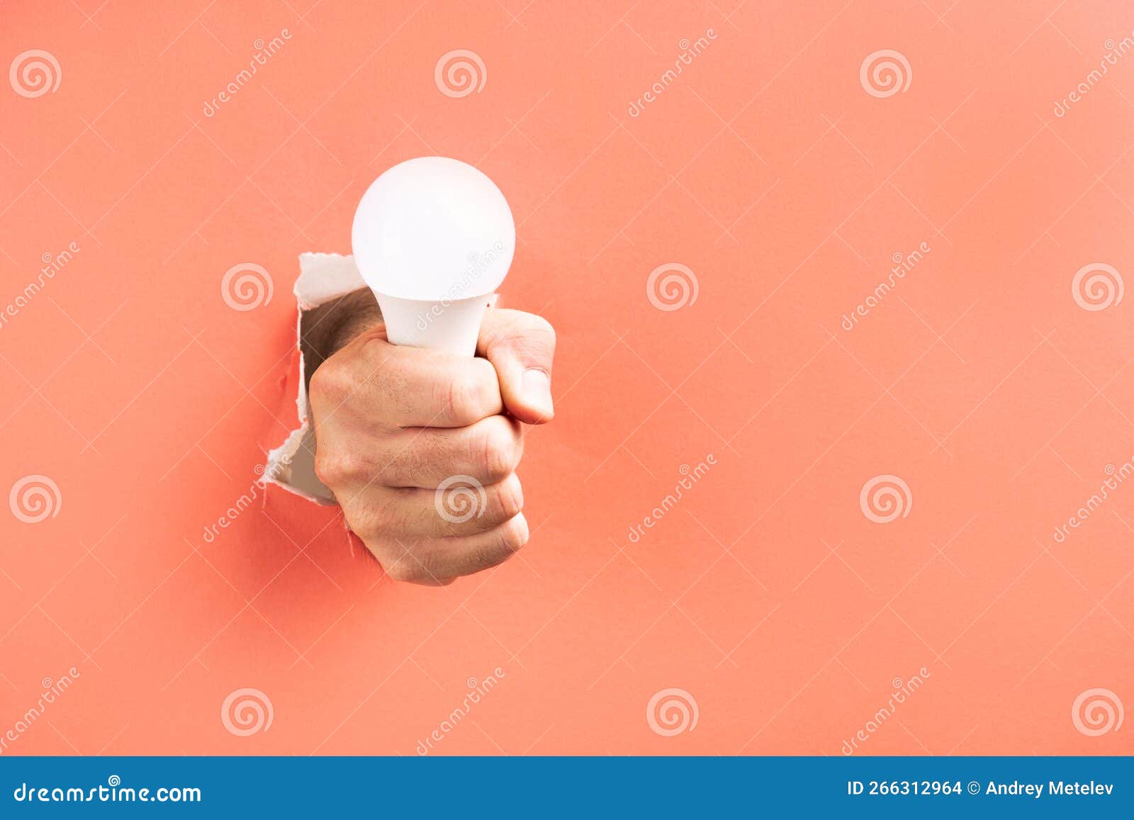 A Hand with a Lamp Breaks through the Paper. through a Hole in the ...
