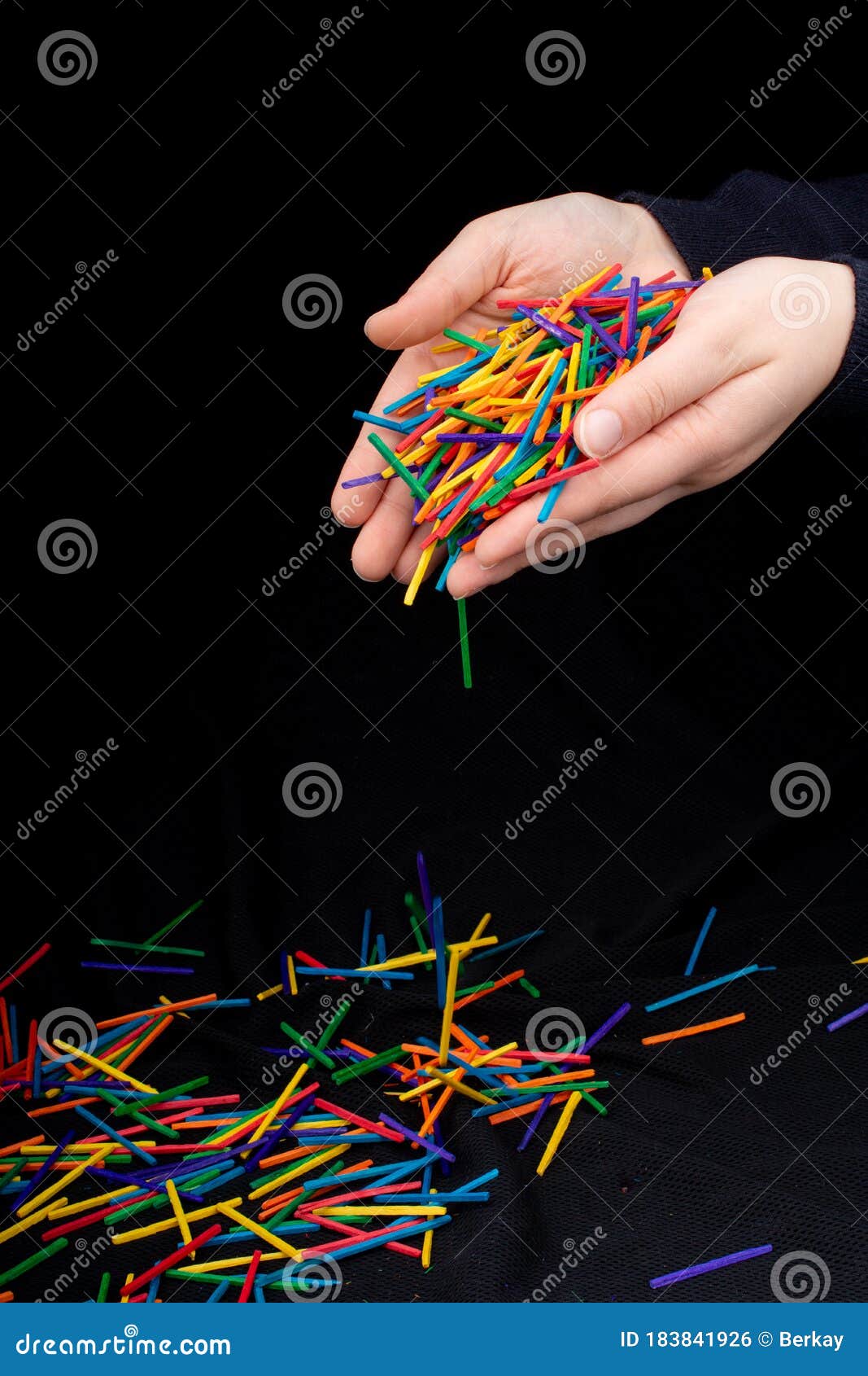 Hand Letting Coloured Wooden Sticks Drop on Black Stock Photo - Image ...