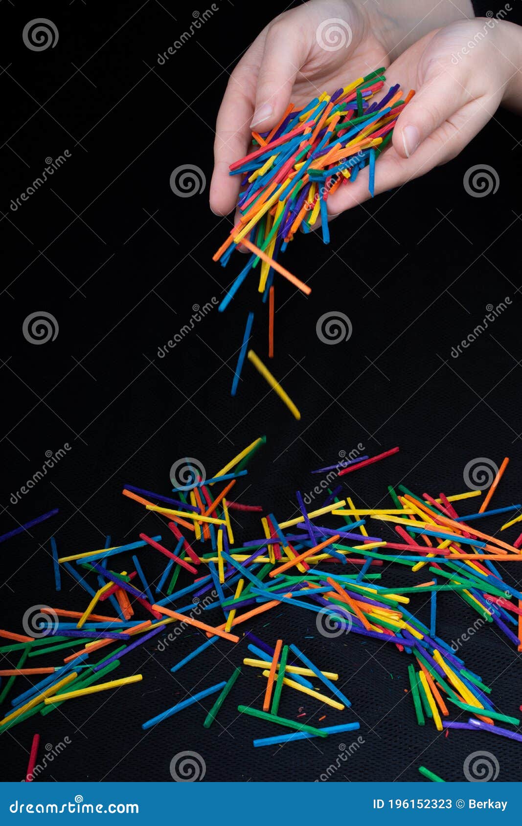 Hand Letting Coloured Wooden Sticks Drop on Black Stock Image - Image ...