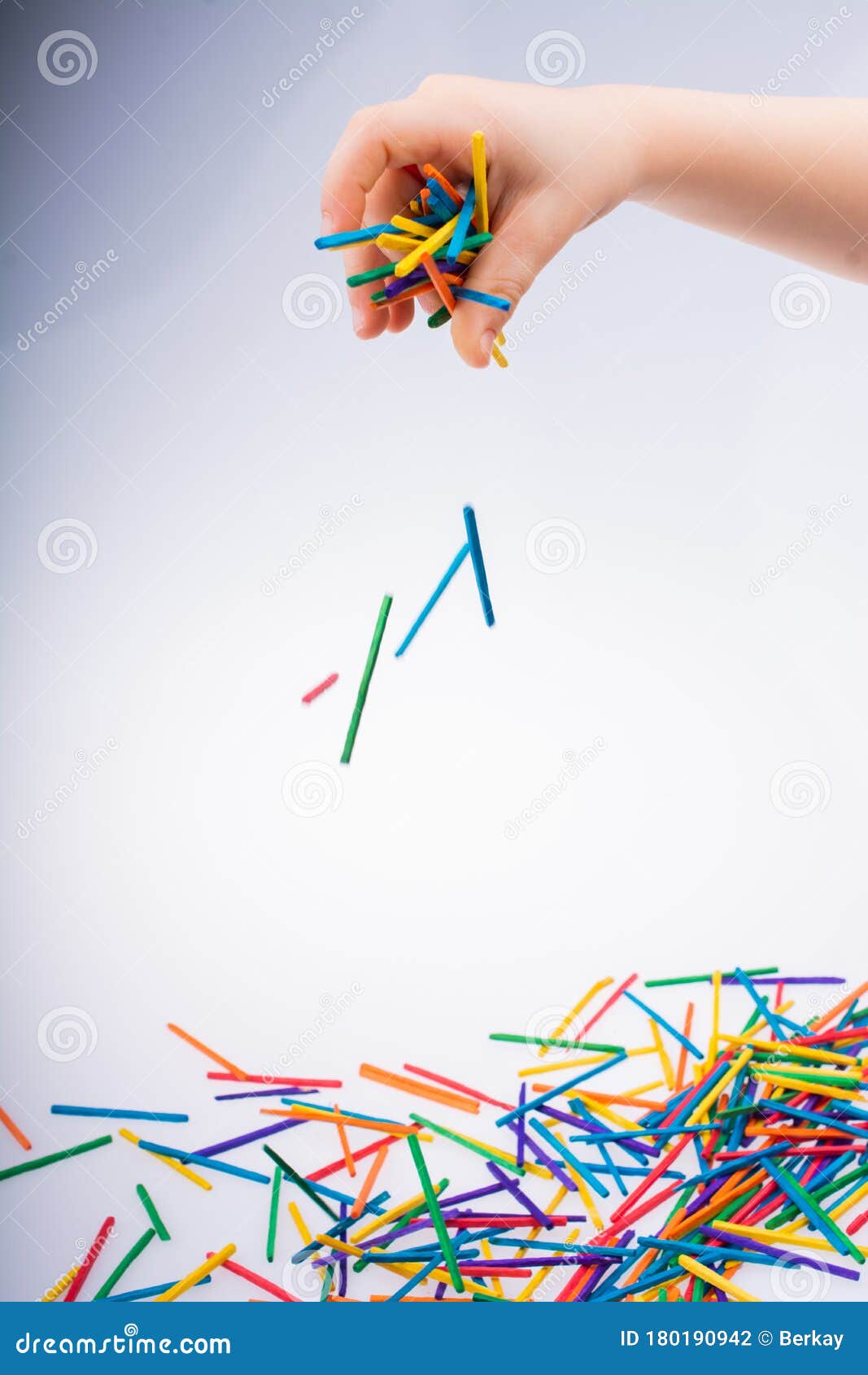 Hand Letting Coloured Wooden Sticks Drop on White Stock Photo - Image ...