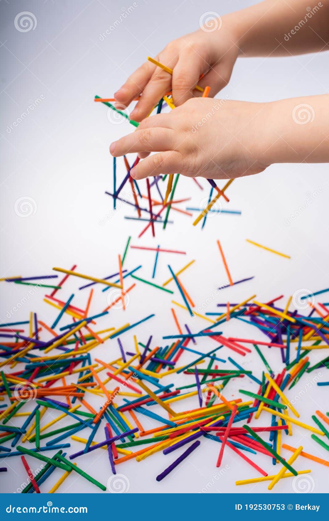 Hand Letting Coloured Wooden Sticks Drop on White Stock Image - Image ...