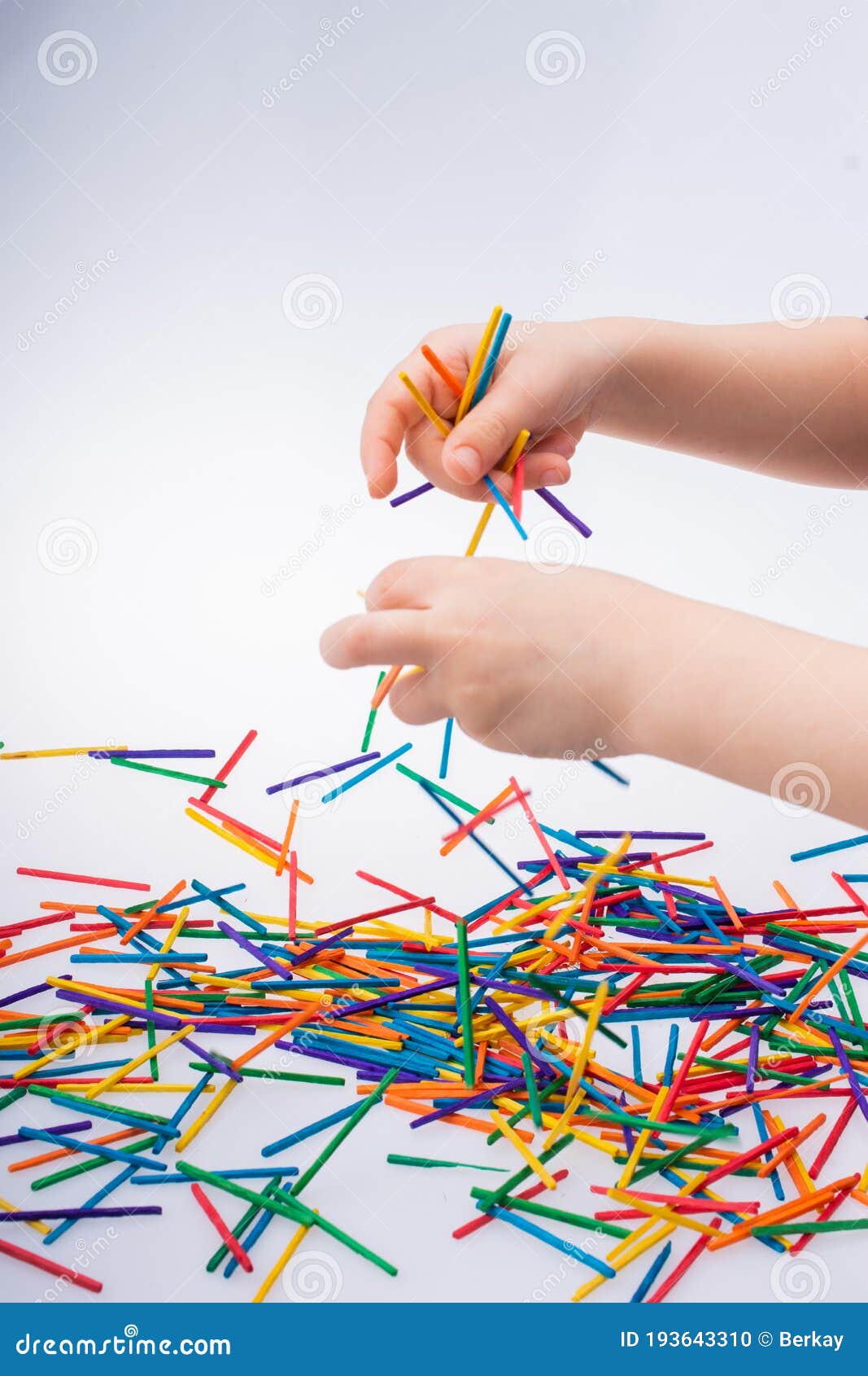 Hand Letting Coloured Wooden Sticks Drop on White Stock Photo - Image ...