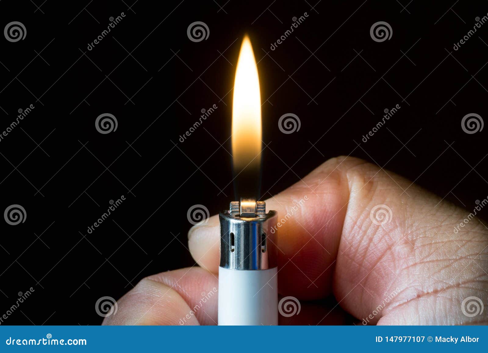 A Hand Lighting Up a Lighter with Flame and Dark Background. Stock ...