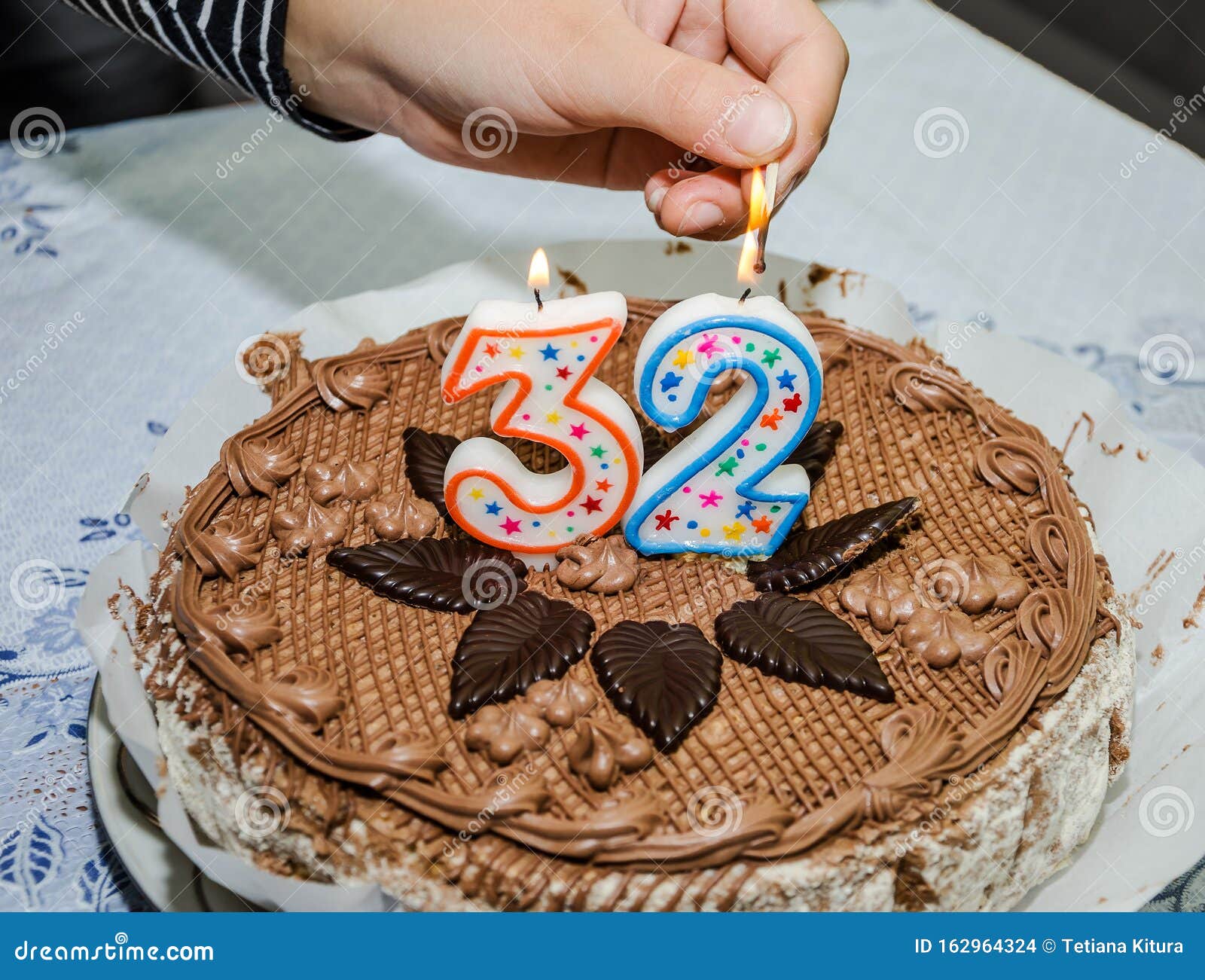 Hand Lights Candles on a Festive Cake. Number 32 on the Cake. Stock ...