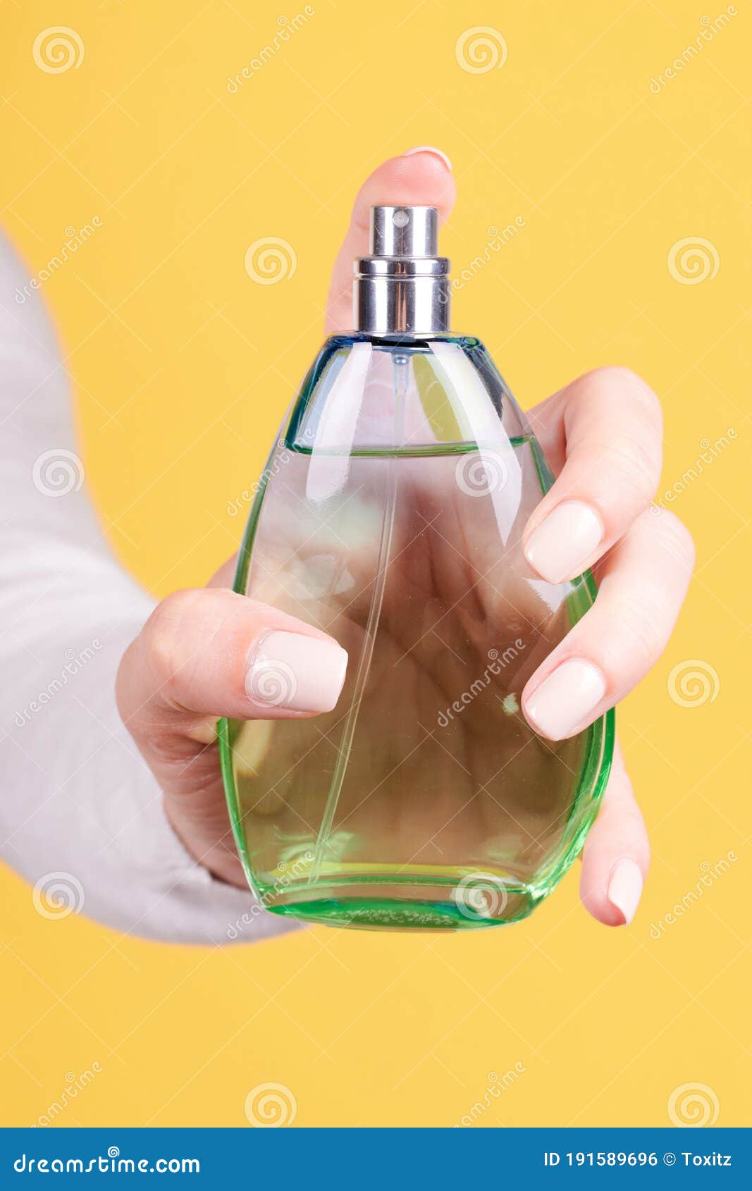 Hand with Luxury Perfume Bottle. Isolated on Yellow Background Stock ...