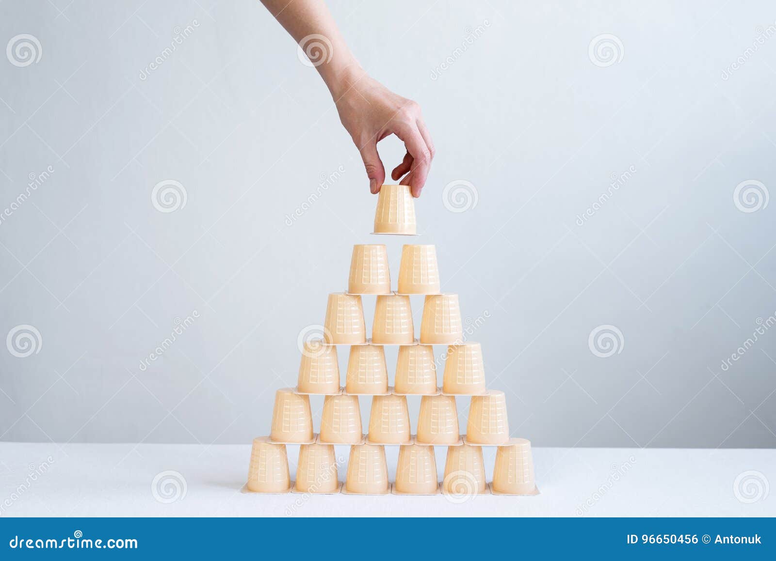 Hand Making a Pyramid from Little Plastic Glasses Stock Photo - Image ...
