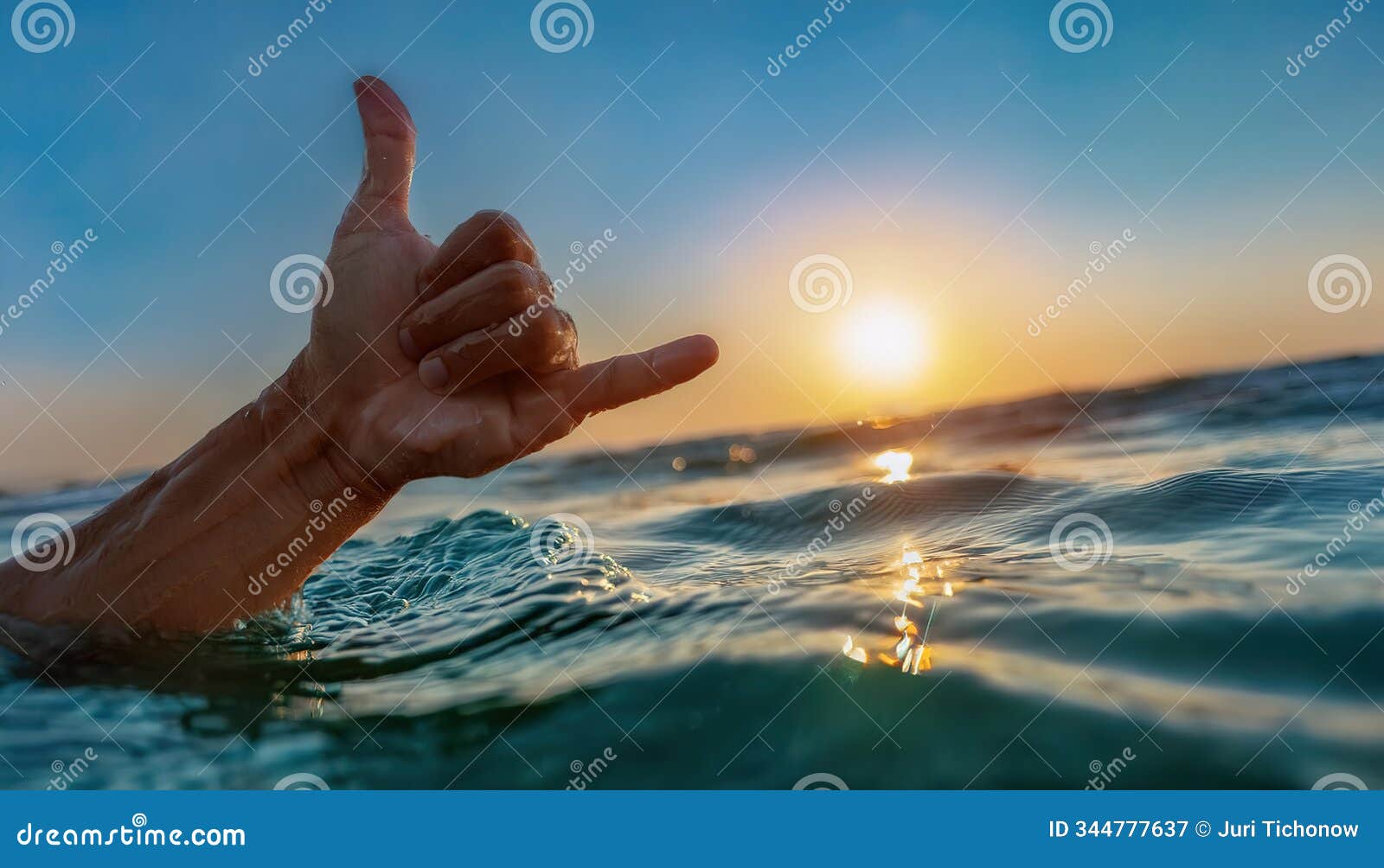 A Hand Making a Shaka Sign in the Ocean Water during a Sunset. Stock ...