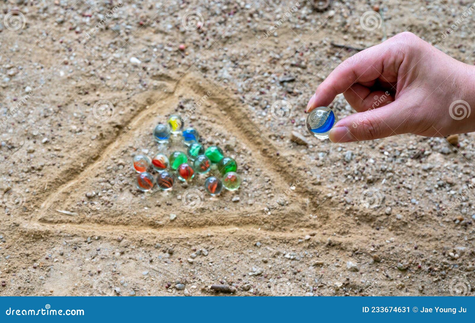 The Hand of a Man Playing Marbles in a Playground with Dirt Stock Image ...