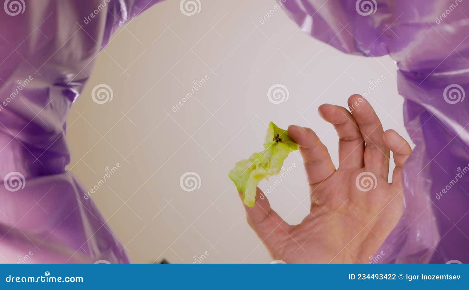 The Hand of a Man Throwing an Apple Core into a Garbage Bag. View from ...