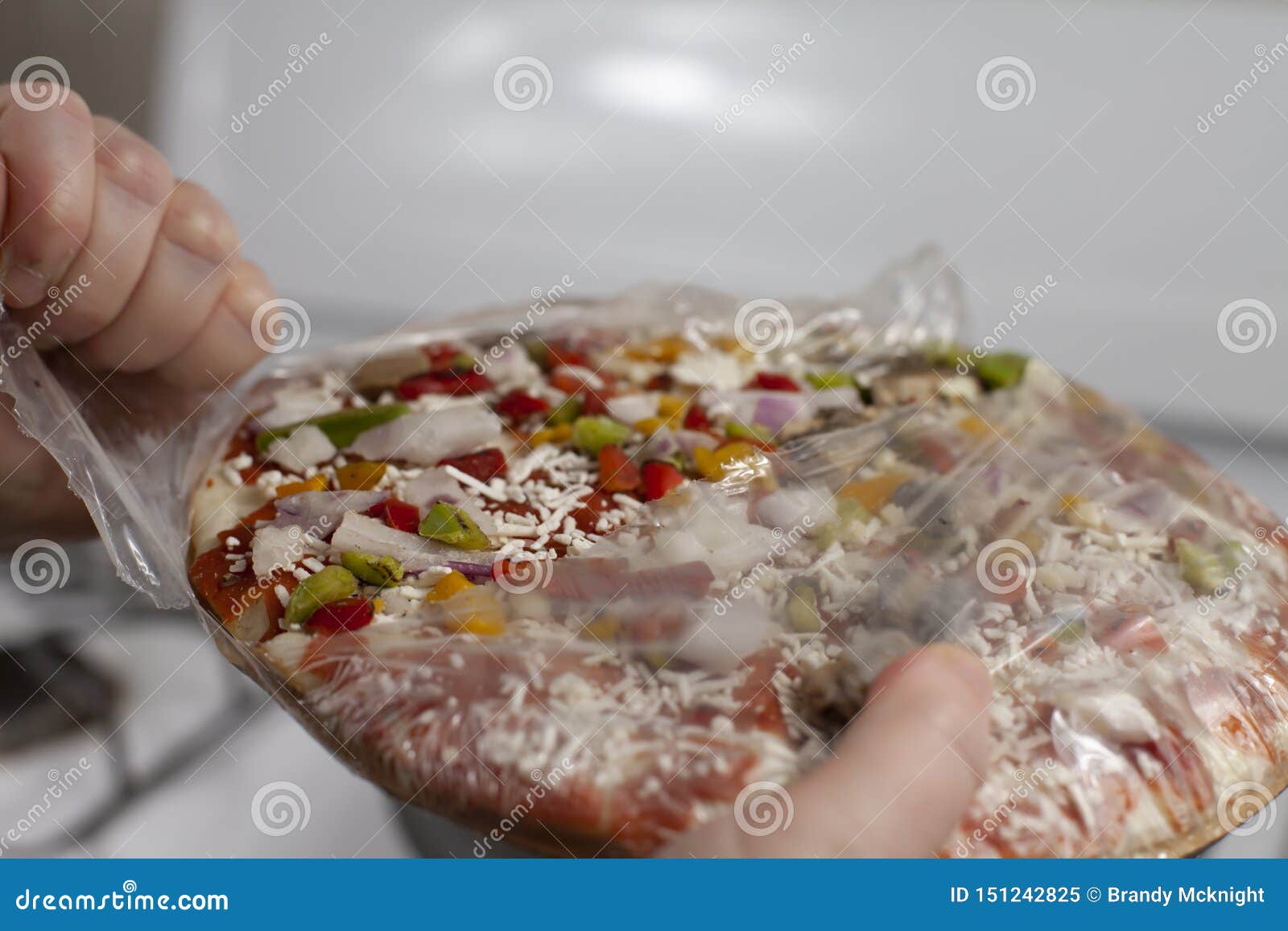 Hand Opening Frozen Pizza stock image. Image of dinner - 151242825