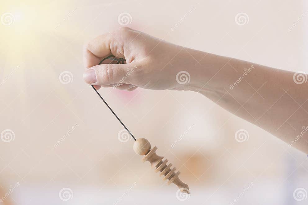 Using big wooden pendulum stock image. Image of hand - 195156921