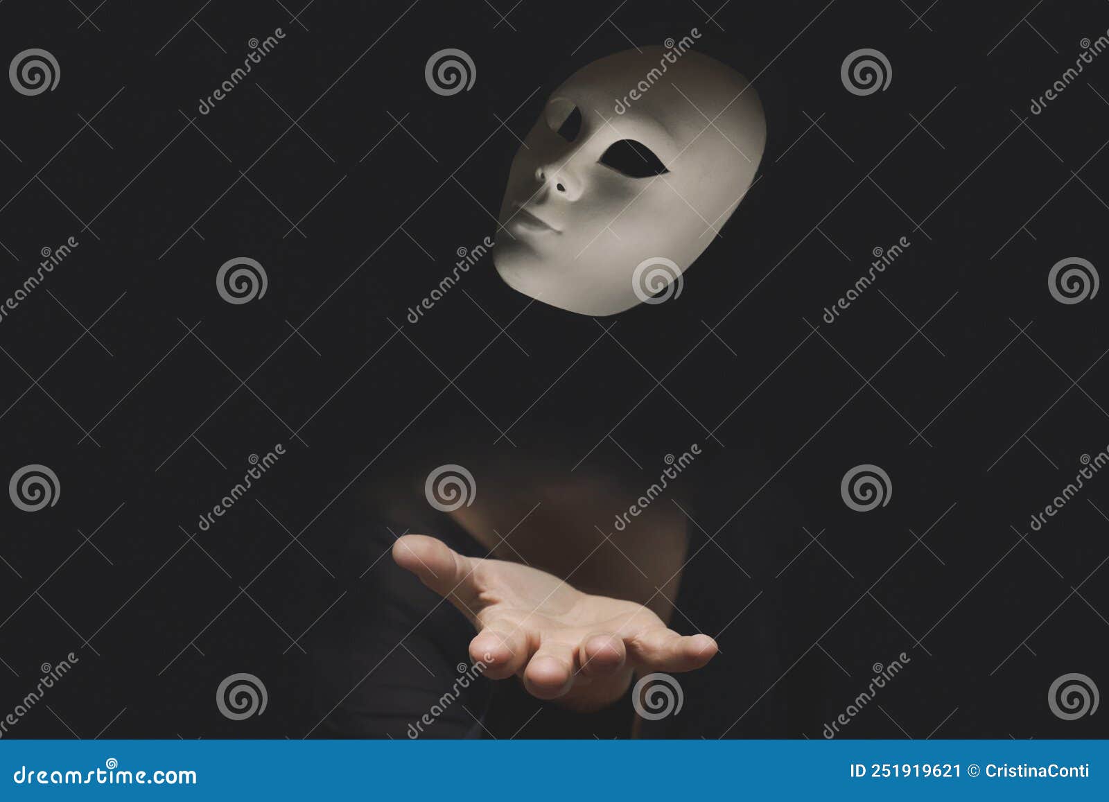 Hand of a Person Hidden in the Dark Throwing a Mask in the Air Stock ...