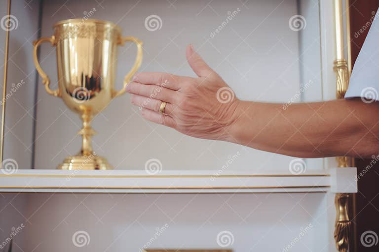 Hand Placing a Golden Cup in a Display Case Stock Photo - Image of ...