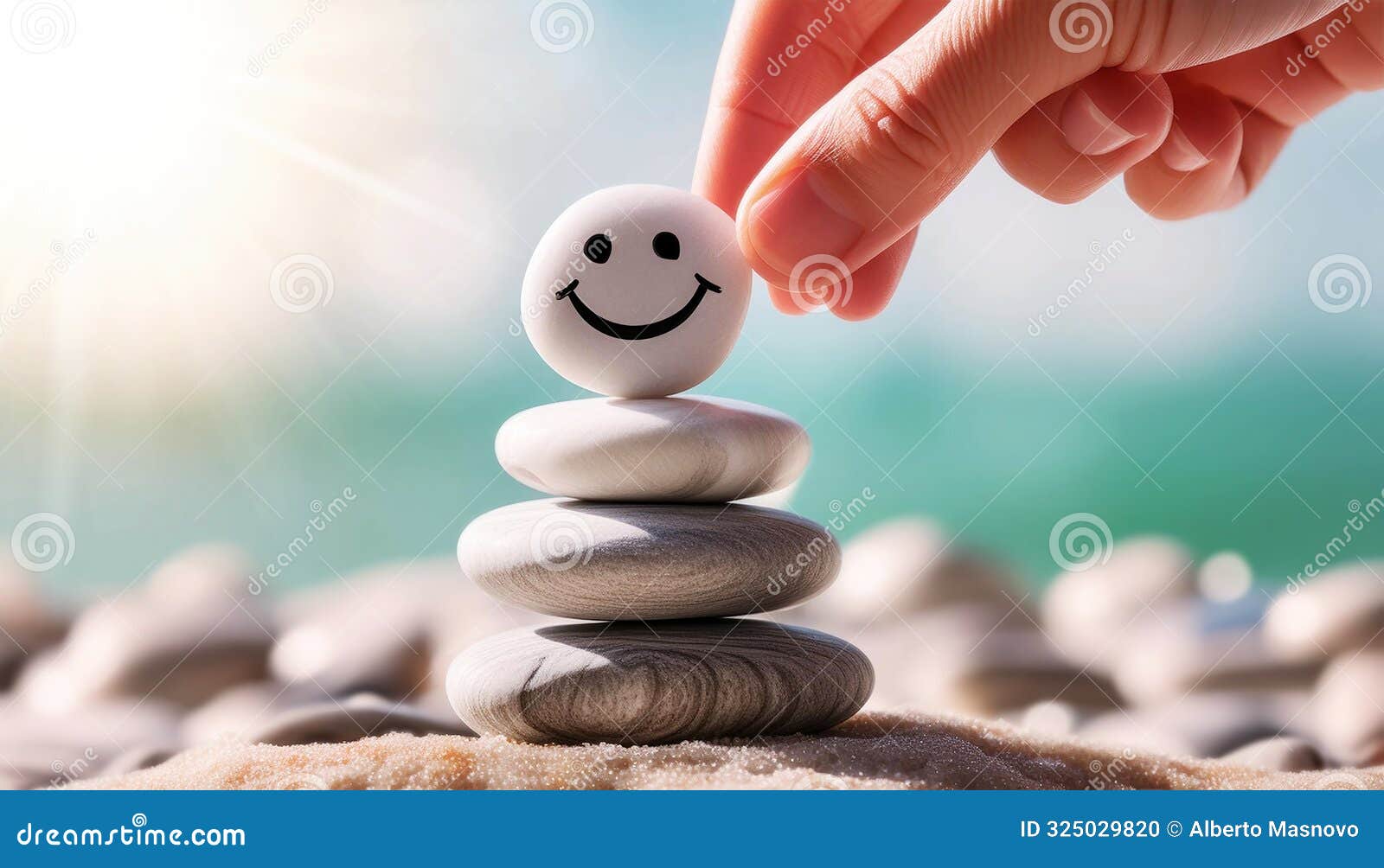 Hand Placing a Pebble with Smiling Face on Top of a Stack of Pebbles ...