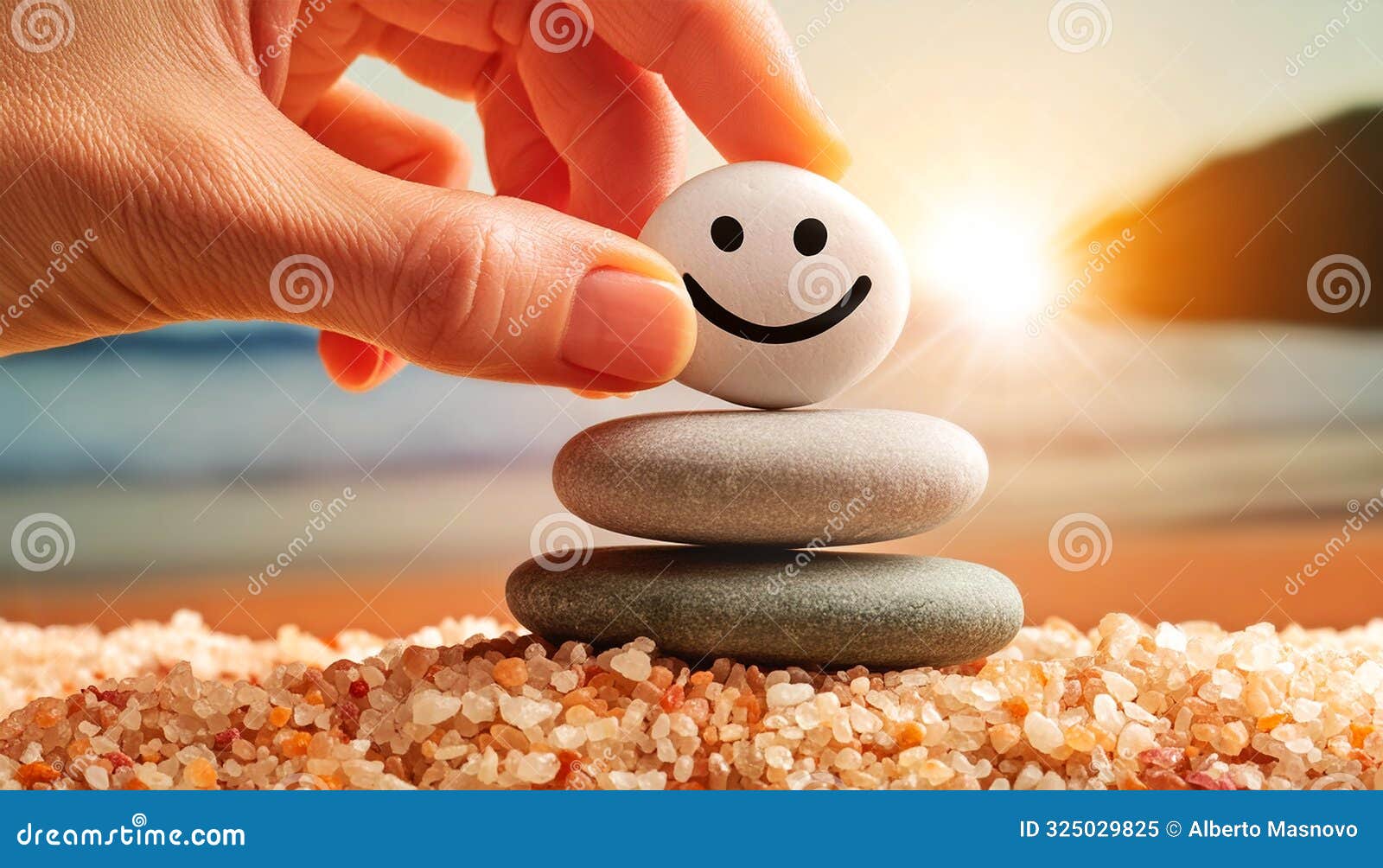 Hand Placing a Pebble with Smiling Face on Top of a Stack of Pebbles ...