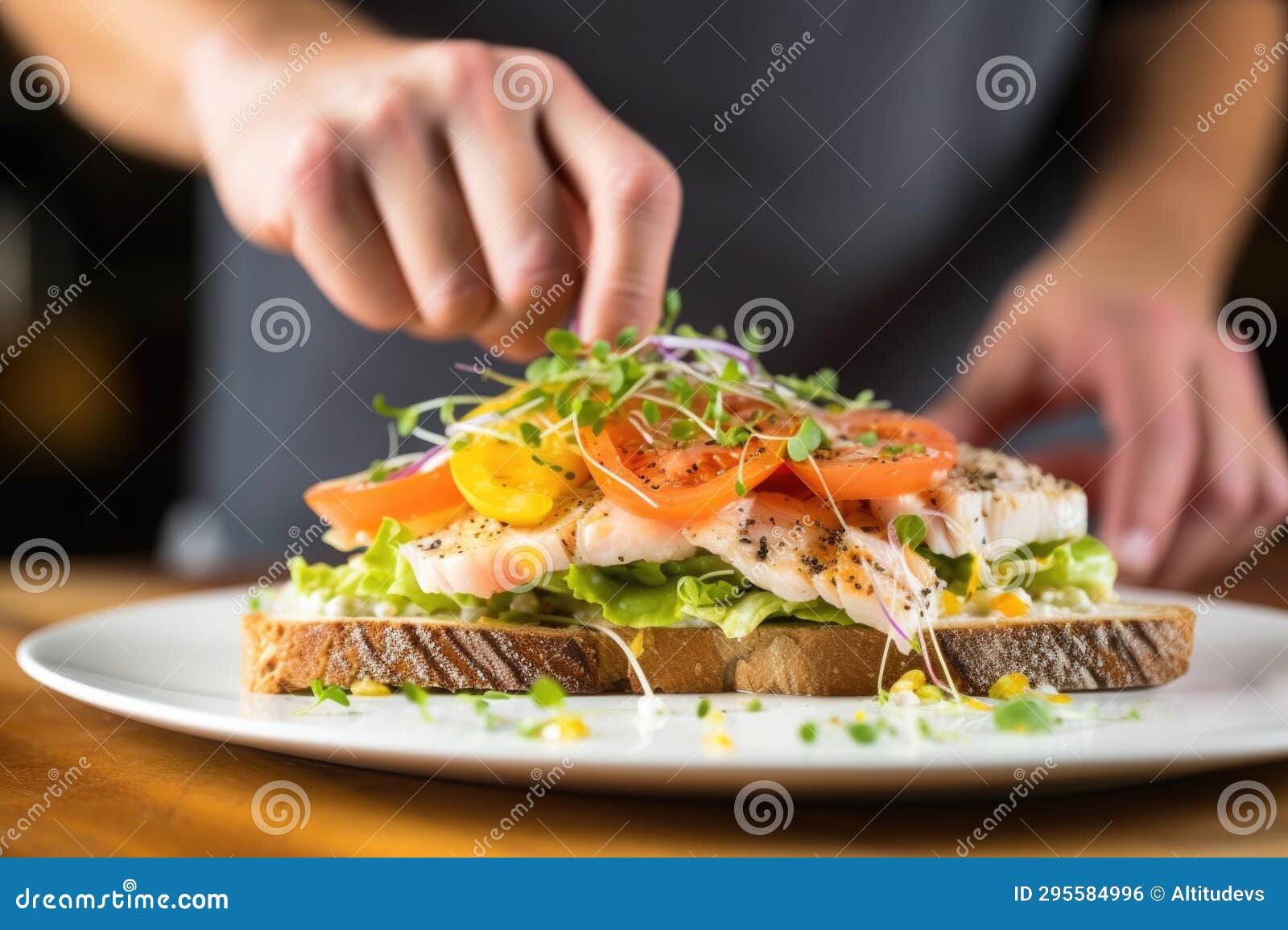 Hand Placing a Piece of Fish on an Open-faced Sandwich Stock Photo ...