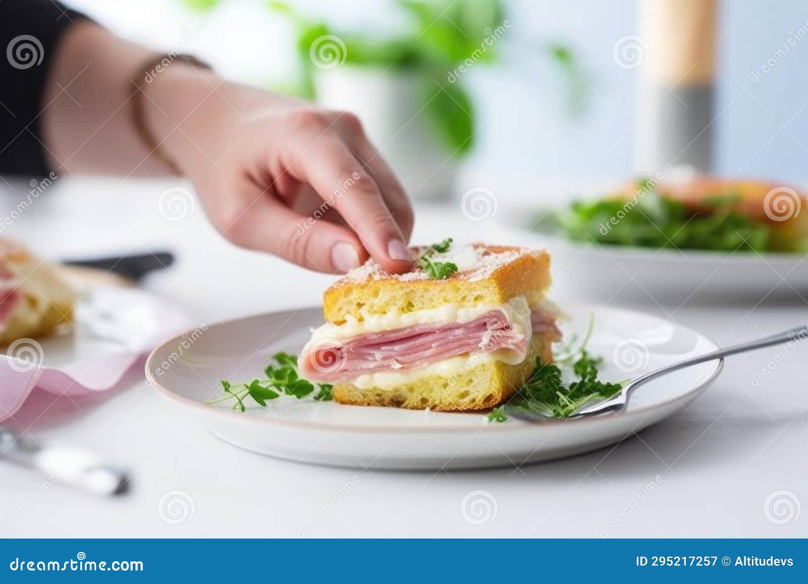 A Hand Placing a Serving of Croque Monsieur on a White Plate Stock ...