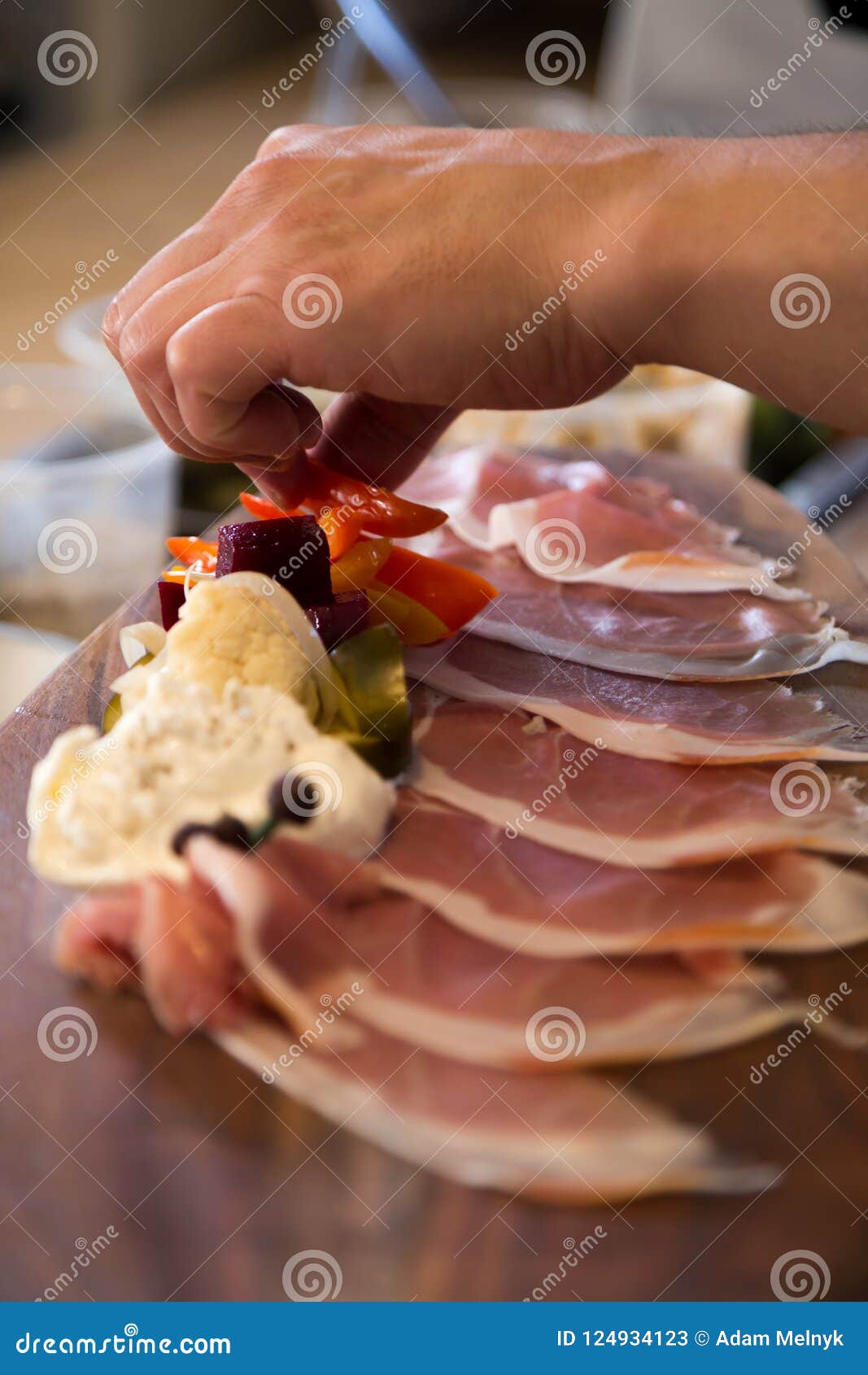 Hand Plating Appetizers on a Wooden Board with Proscuitto. Stock Image ...