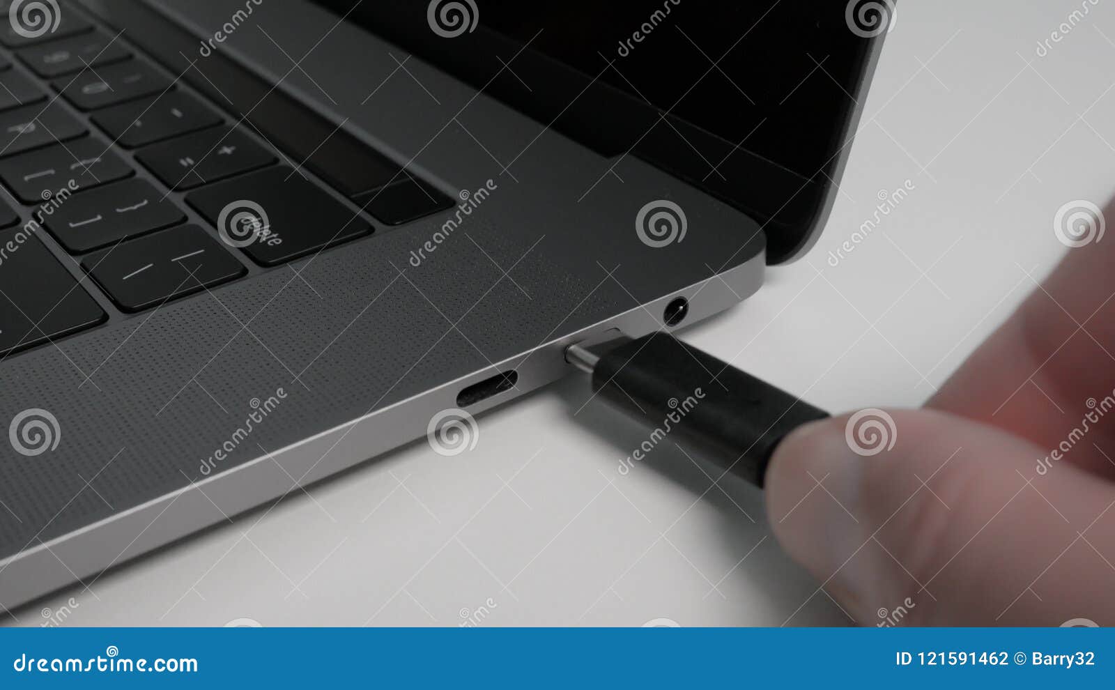 Hand Plugging in a Black USB-C / USB Type-C Cable To a Laptop Computer ...