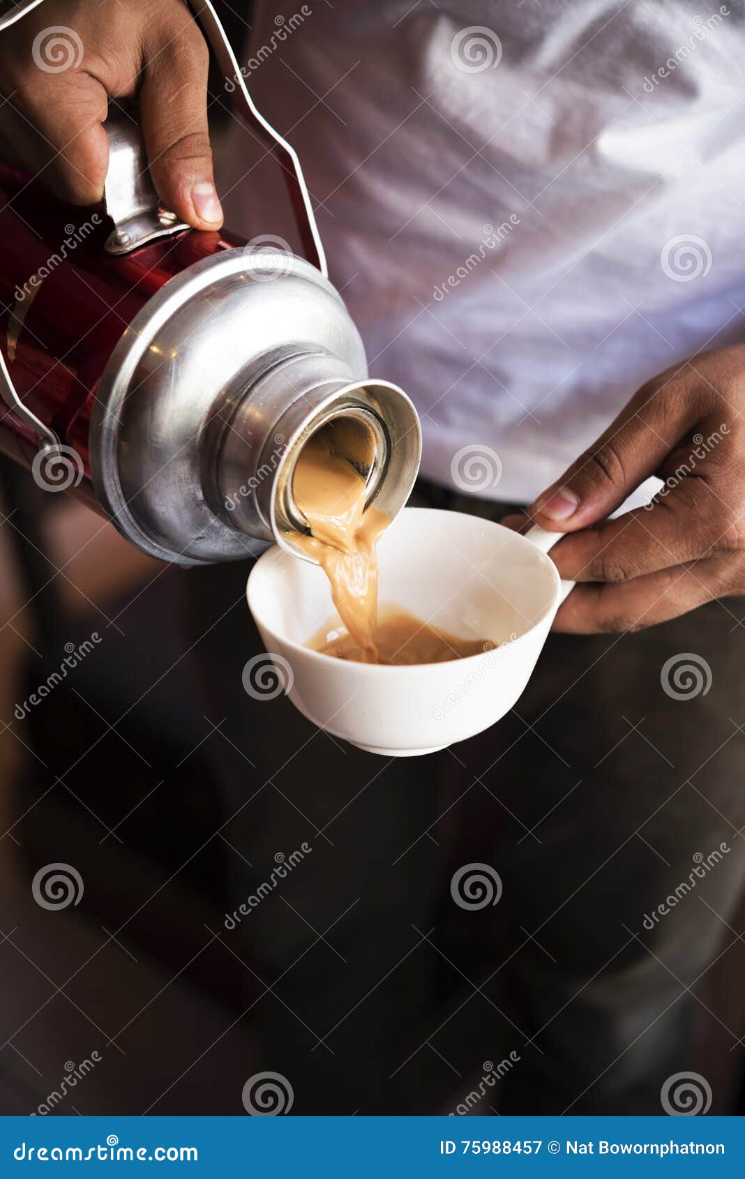 Hand Pouring Traditional Indian Masala Tea into White Ceramic Cu Stock ...