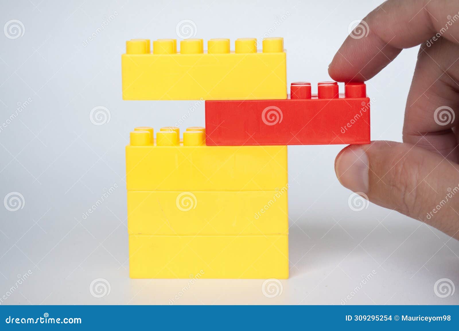 Hand Pulling Red Lego from the Rest. Building Concept Stock Photo ...