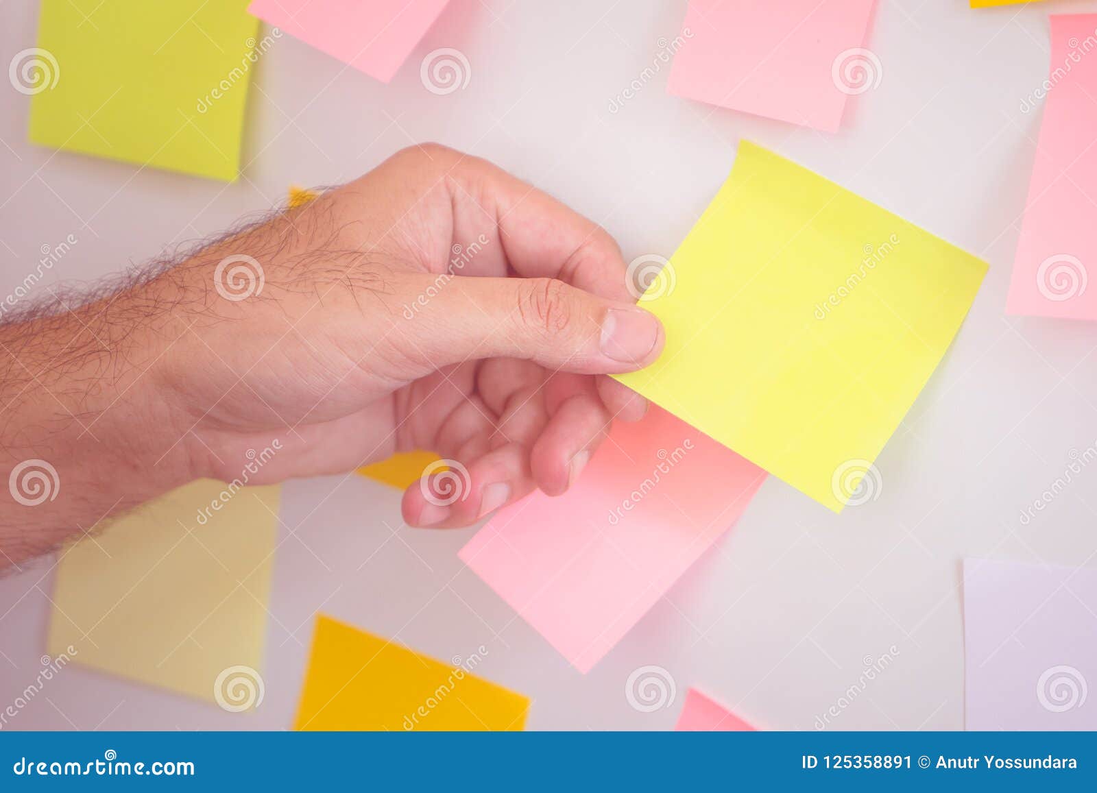 Pulling Reminder Posted Note Paper Out of the Board Stock Image - Image ...