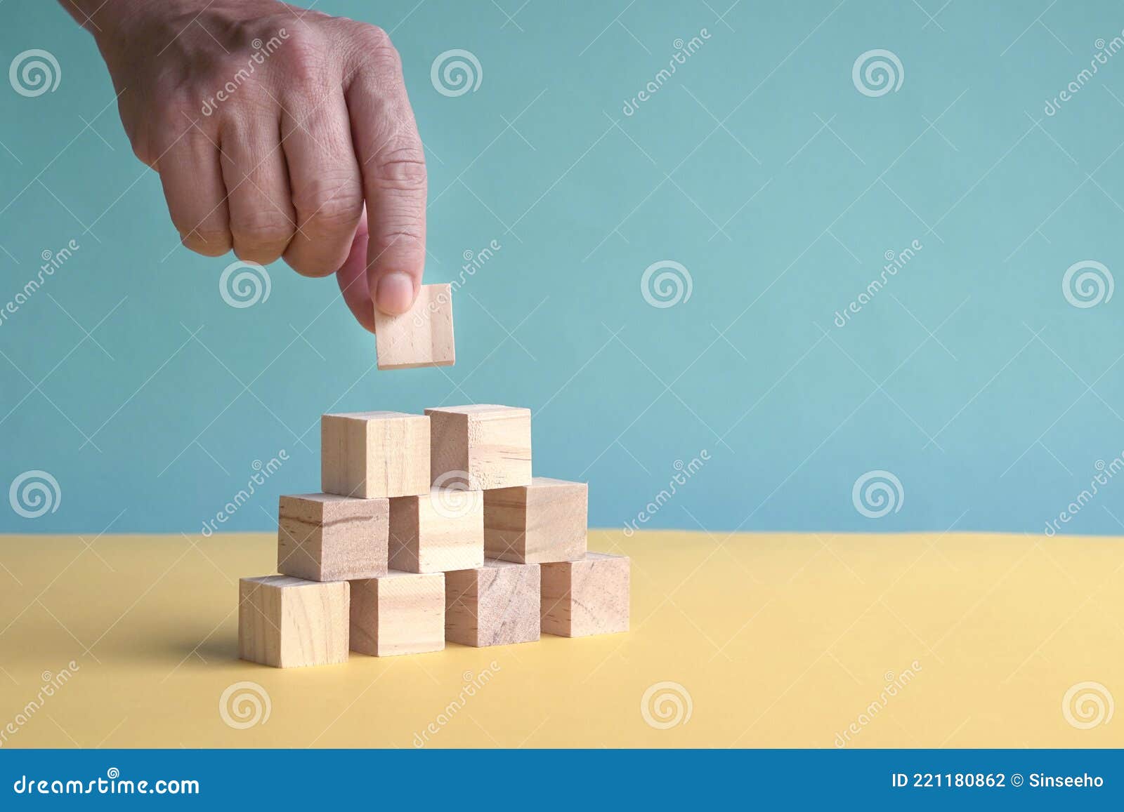 Hand Putting a Square Wood Block on Pyramid Stack of Wood Blocks Stock ...