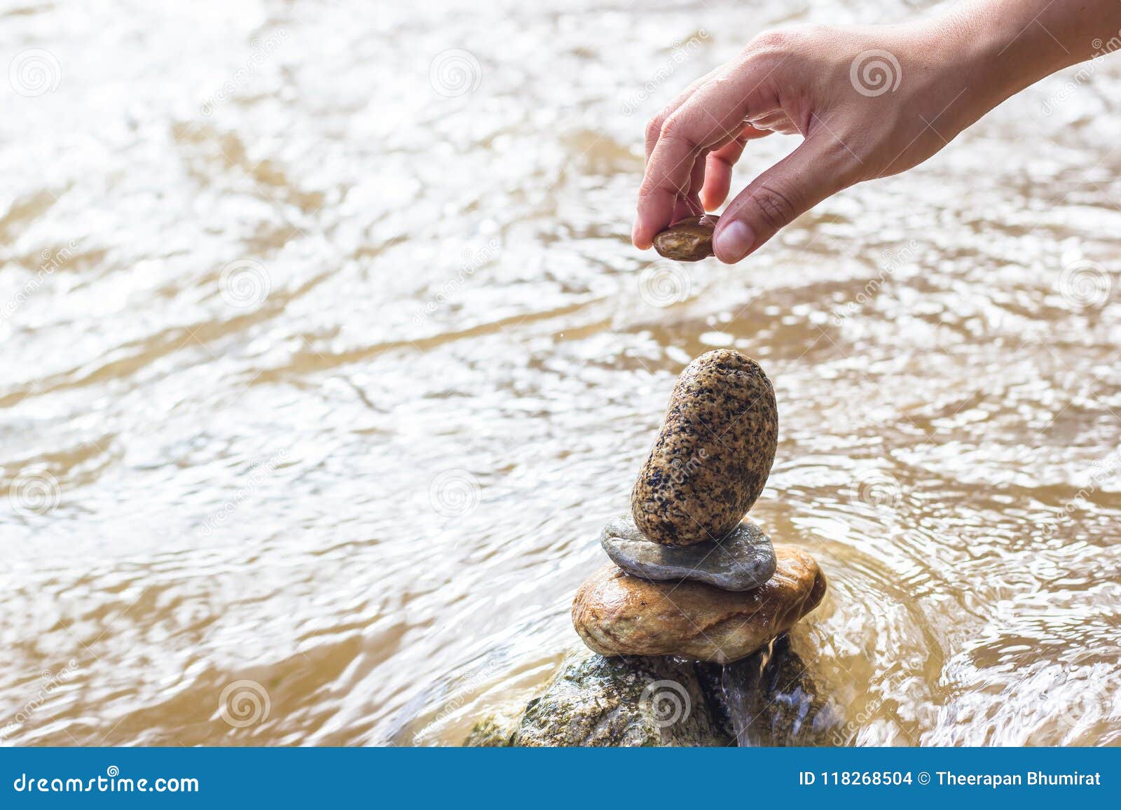 Hand Putting Stone on Stacking Stones on the Riverside. the Sto Stock ...