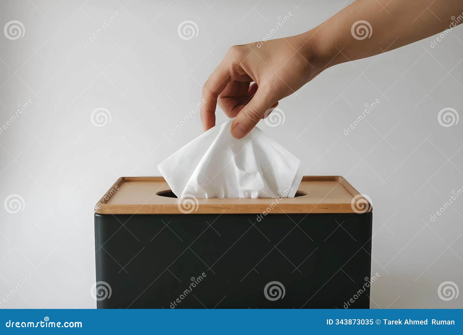 A Hand Reaches Into A Black Tissue Box With A Wooden Top, Pulling Out A ...