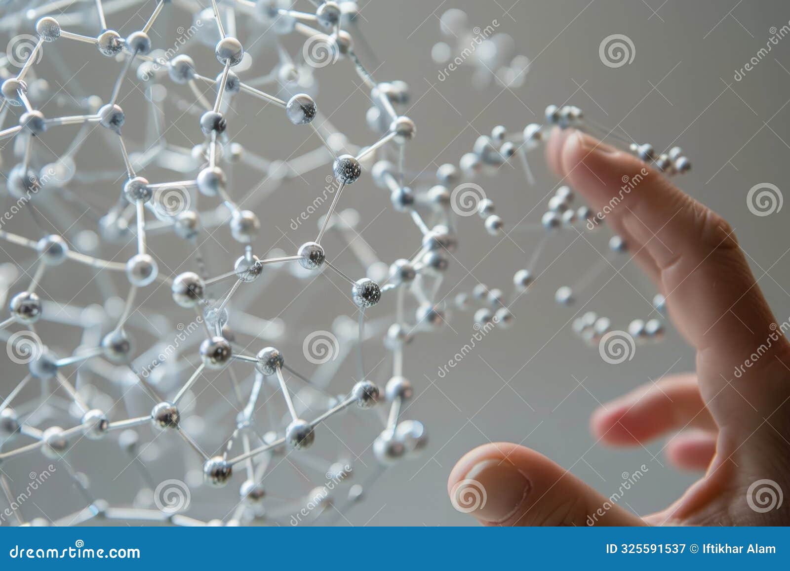 A Hand Reaches for a Silver Complex of Spheres, Symbolizing Atom ...