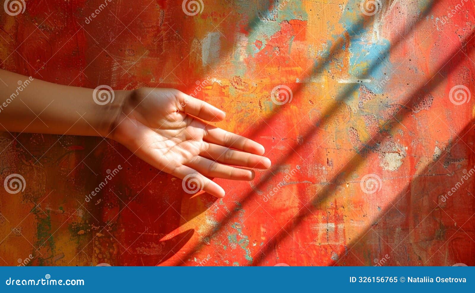 Hand Reaching Out Towards a Vibrant Textured Wall with Sunlight Casting ...