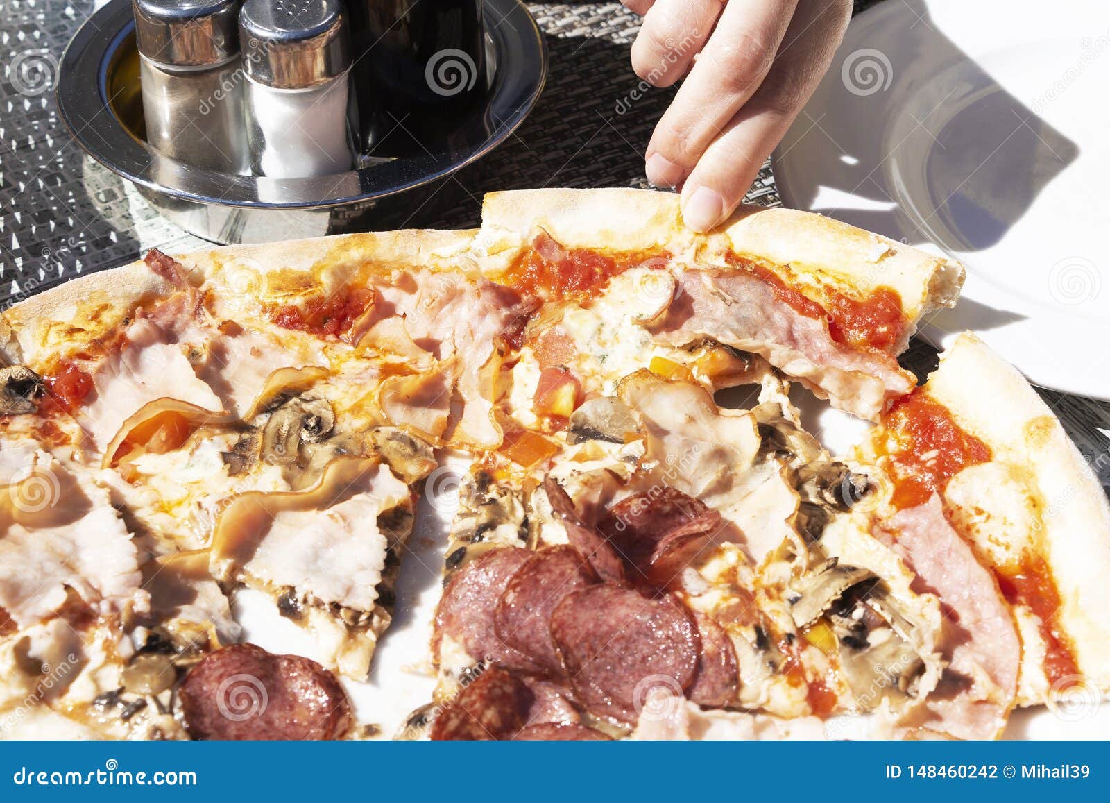 Hand Reaching To Take a Slice of Pizza in the Cafe. Selective Focus ...