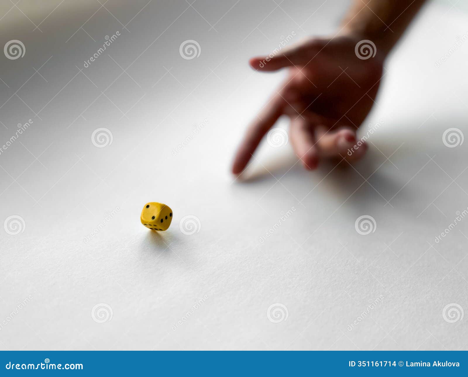 Hand Rolling Yellow Dice on White Surface Representing Chance and Risk ...