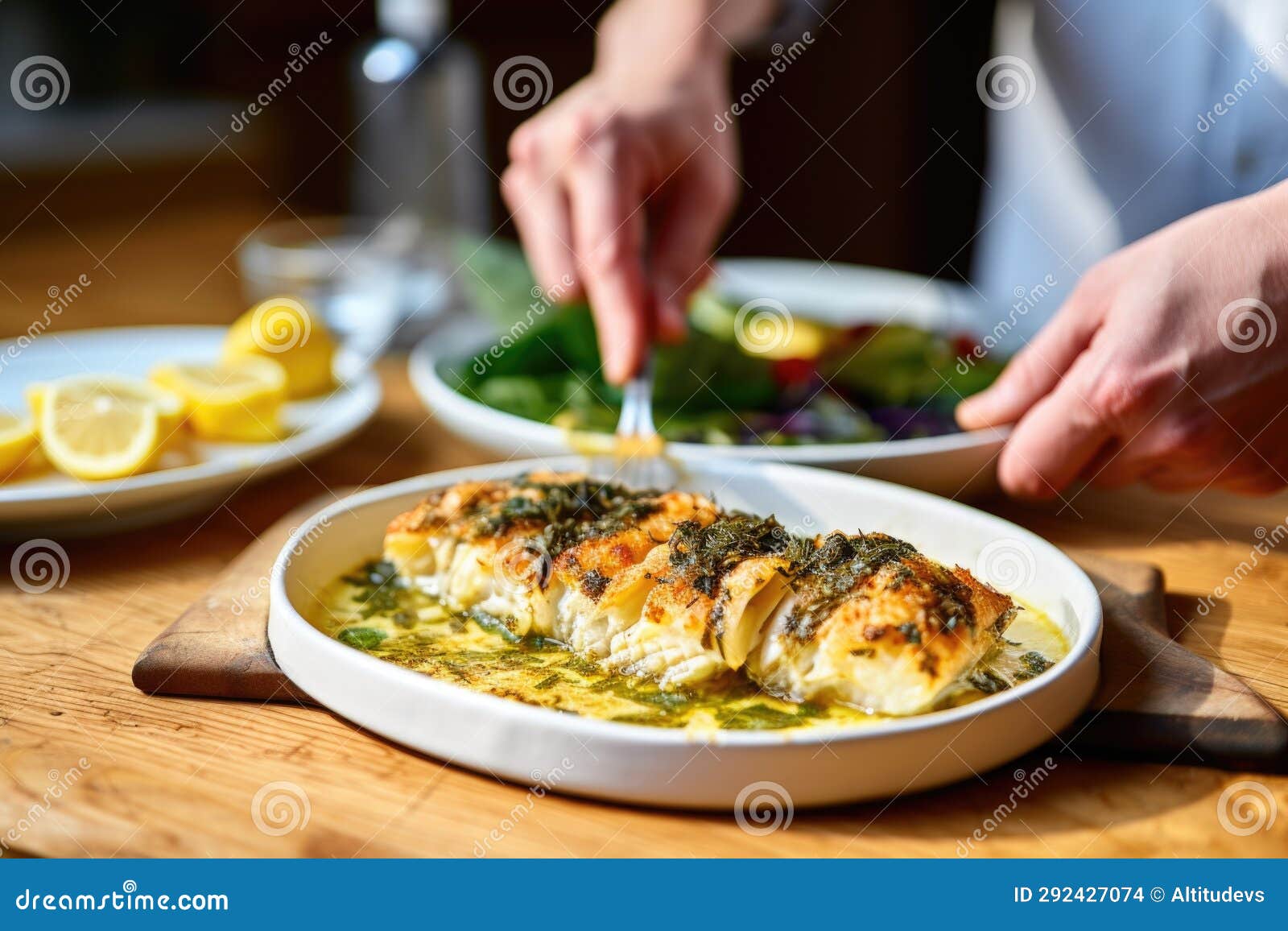 Hand Serving a Superbaked Lemon Cod Onto a Wooden Dining Table Stock ...