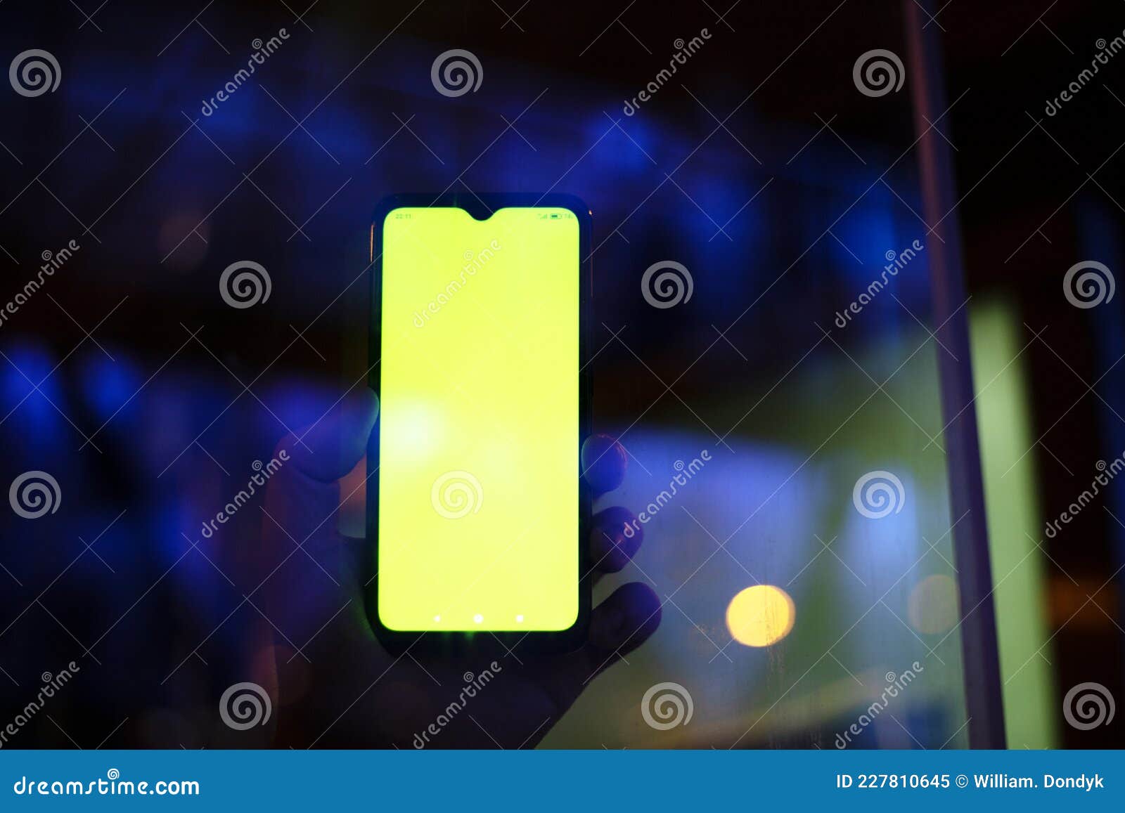 HAND SHOWING CELL PHONE SCREEN at NIGHT with BLUE LIGHTS BACKGROUND ...