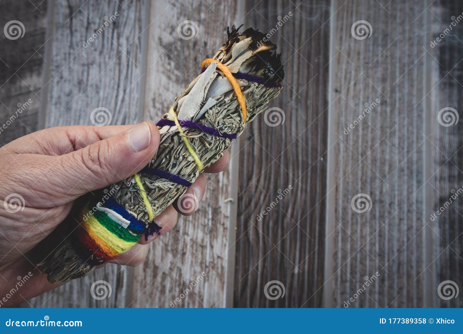 Hand Smudging with a Bundle of Burning Sage in Front of Wood Background ...