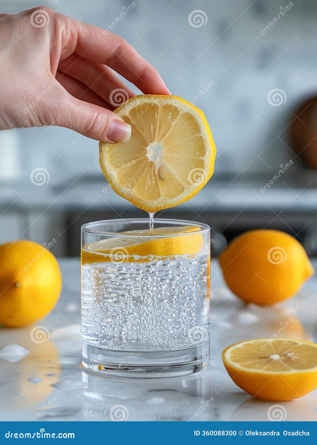 Hand Squeezing a Lemon into a Glass of Sparkling Water Stock Photo ...