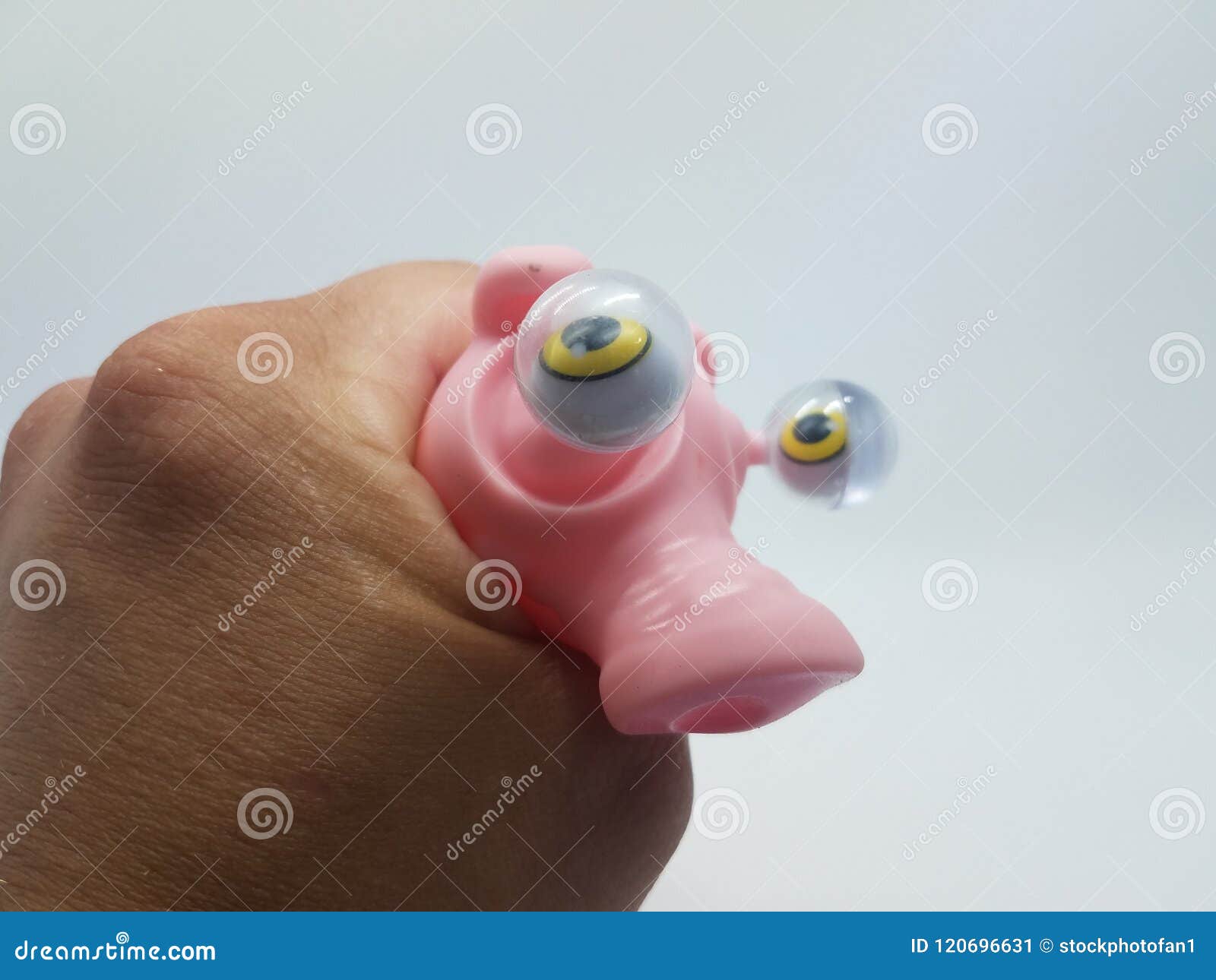 Hand Squeezing a Plastic Pink Pig with Eyes Bulging Out Stock Image ...