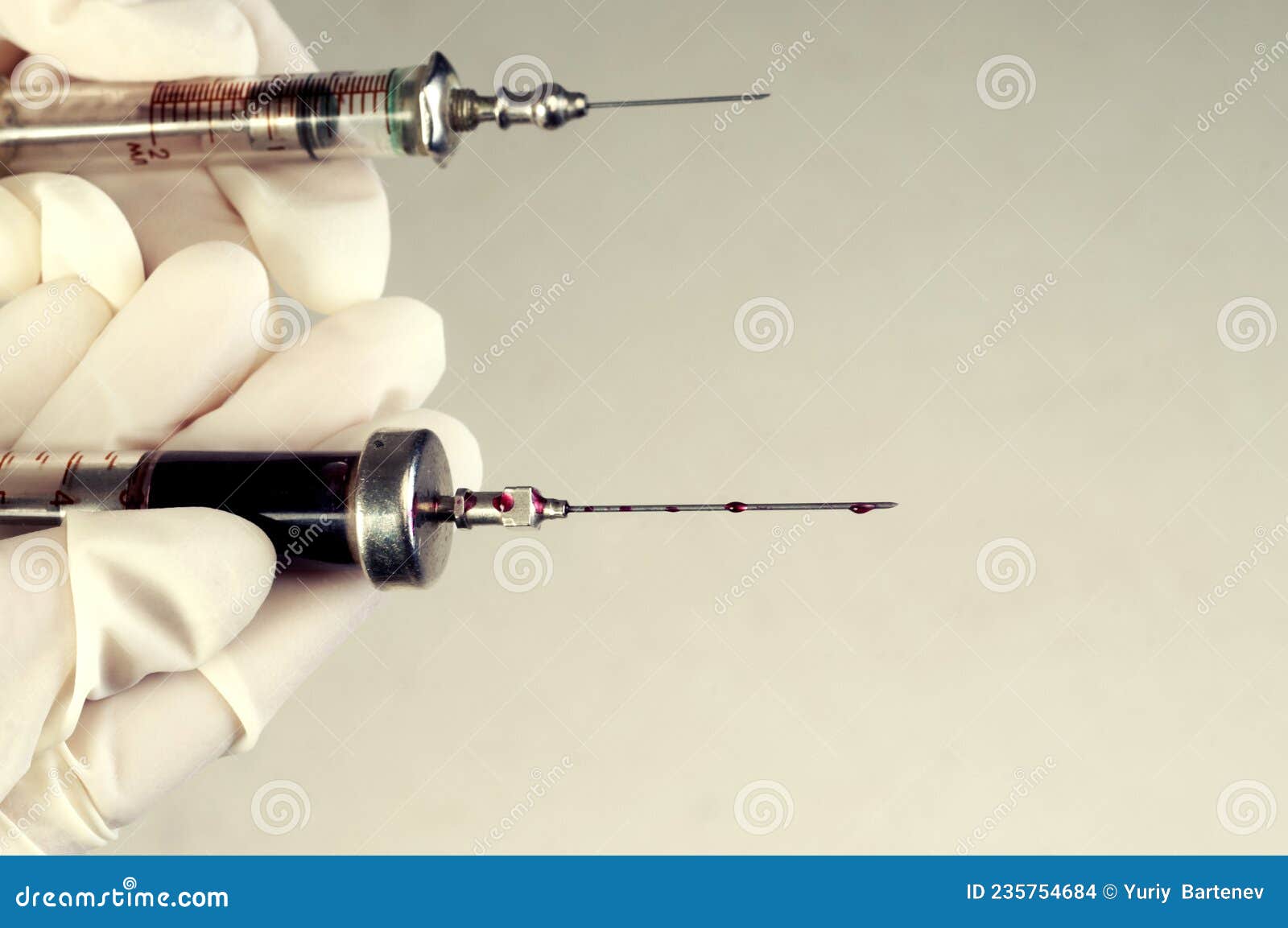 Hand Squeezing Two Old Glass Syringe with a Sharp Needle. Stock Photo ...
