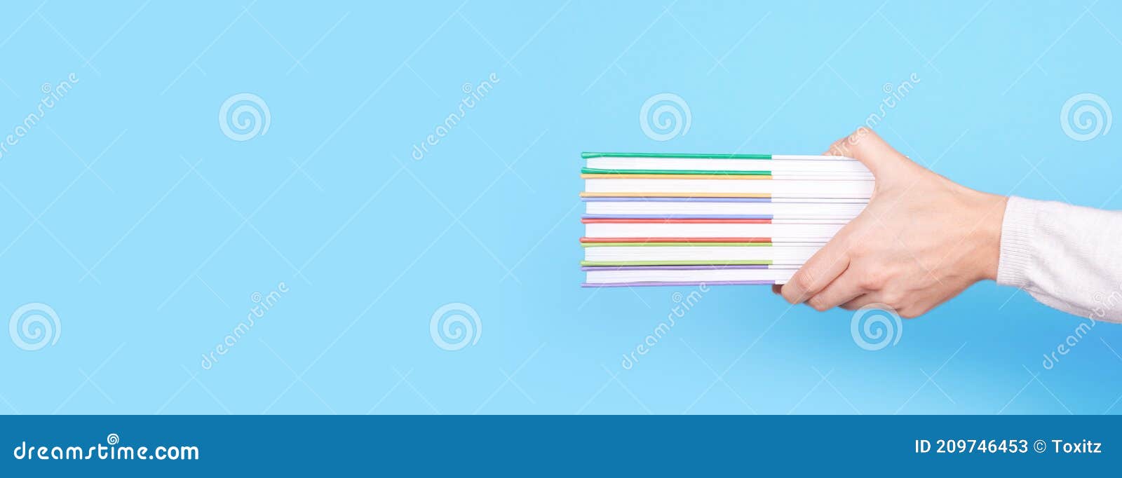 Hand with Stack of Books on Blue Background Stock Image - Image of ...