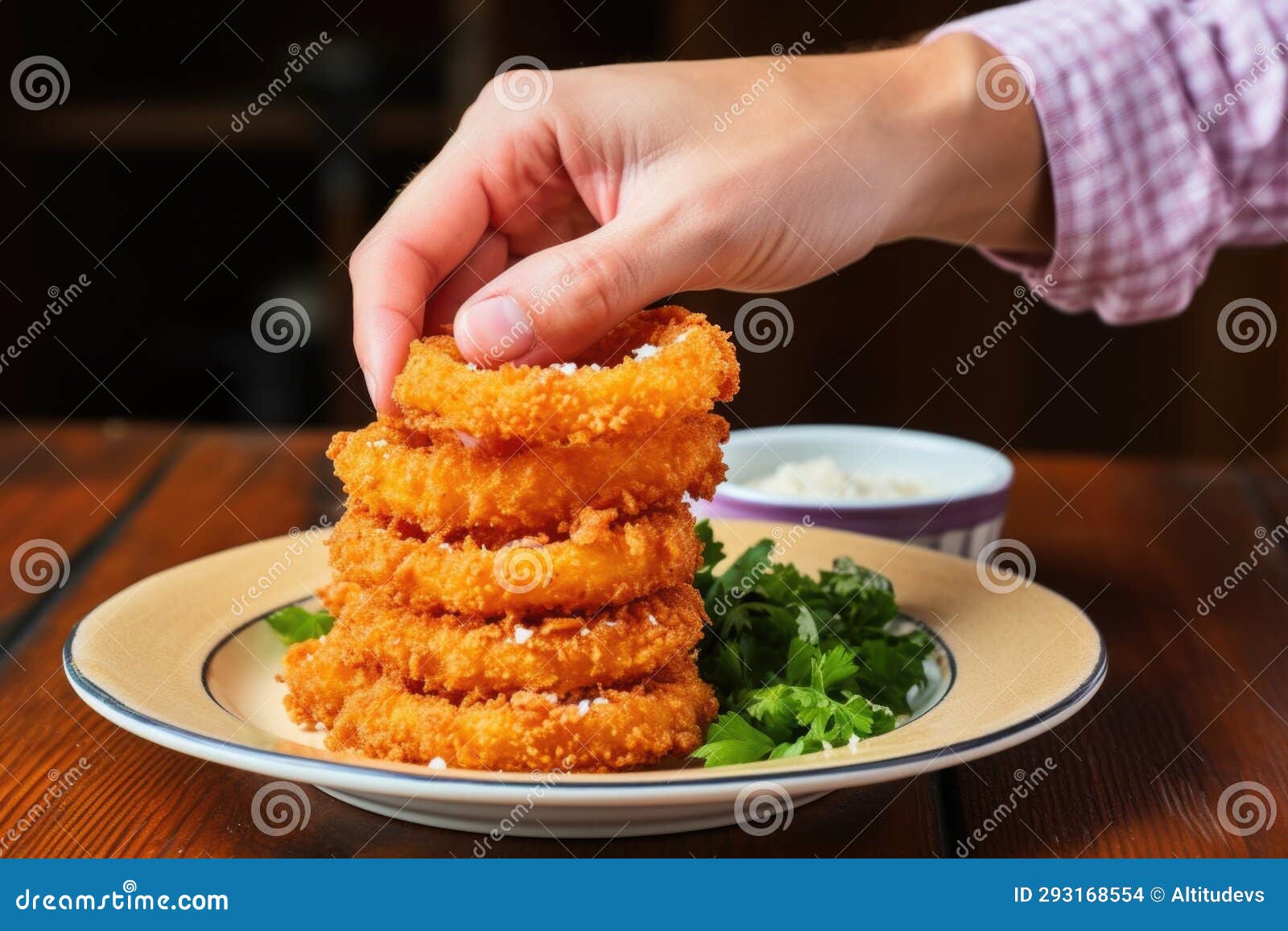 Hand Stacking Onion Rings High on a Plate Stock Illustration ...