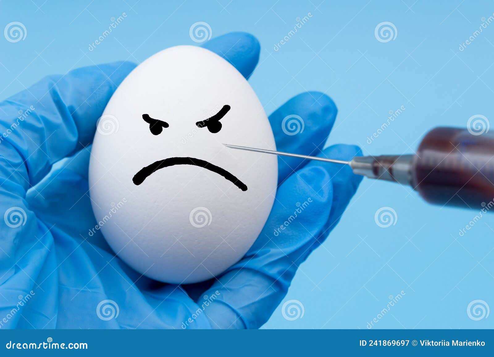 A Hand with a Syringe Makes an Injection into the Egg Close-up. the ...