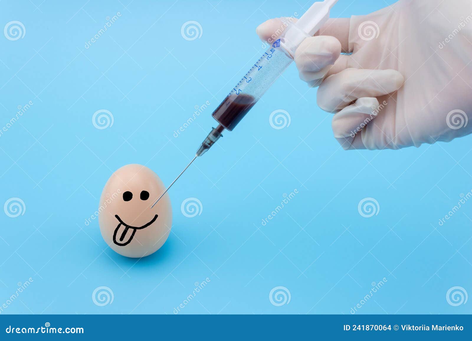 A Hand with a Syringe Makes an Injection into the Egg Close-up. the ...